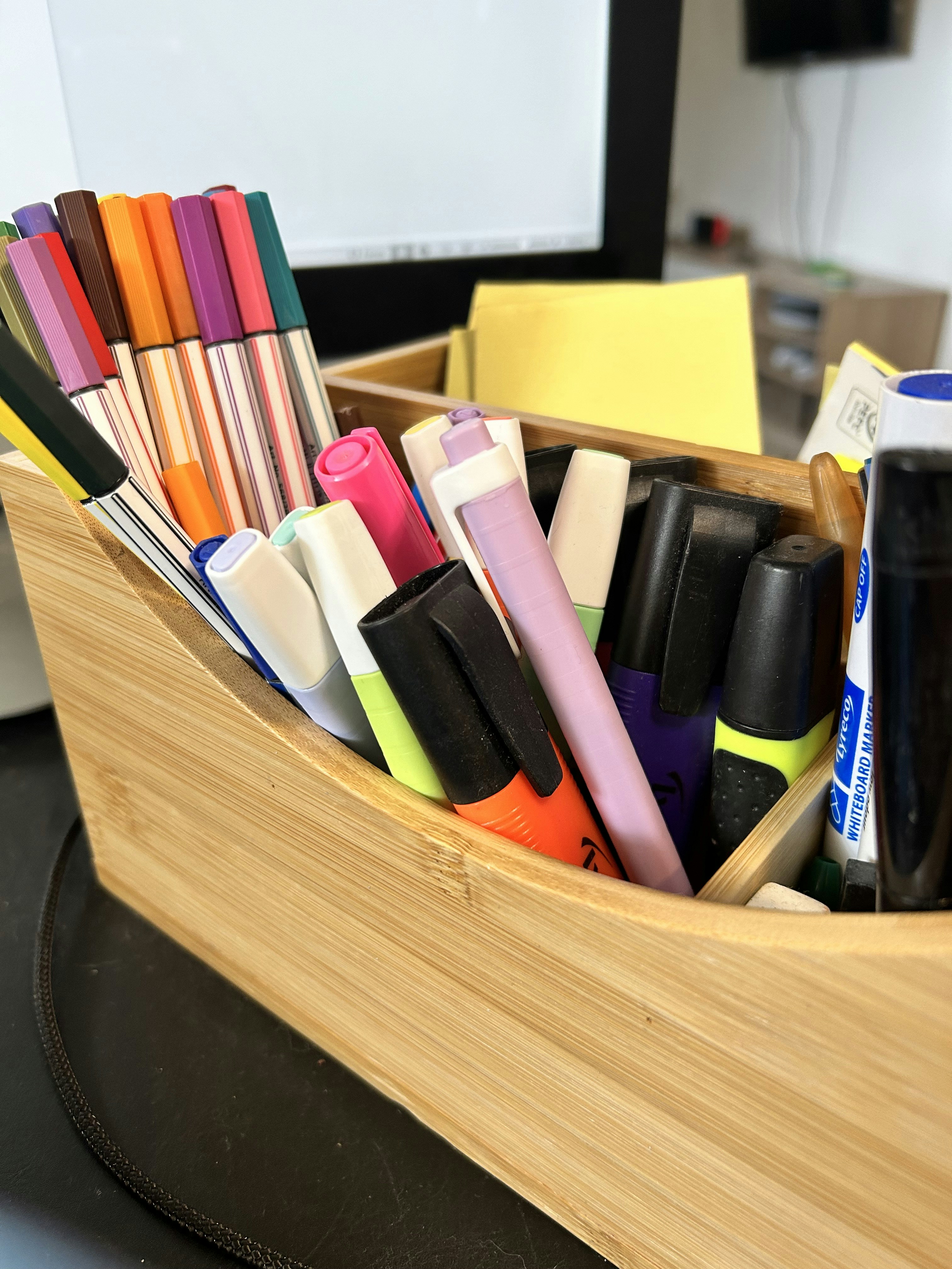 A wooden container filled with lots of different colored pens photo ...