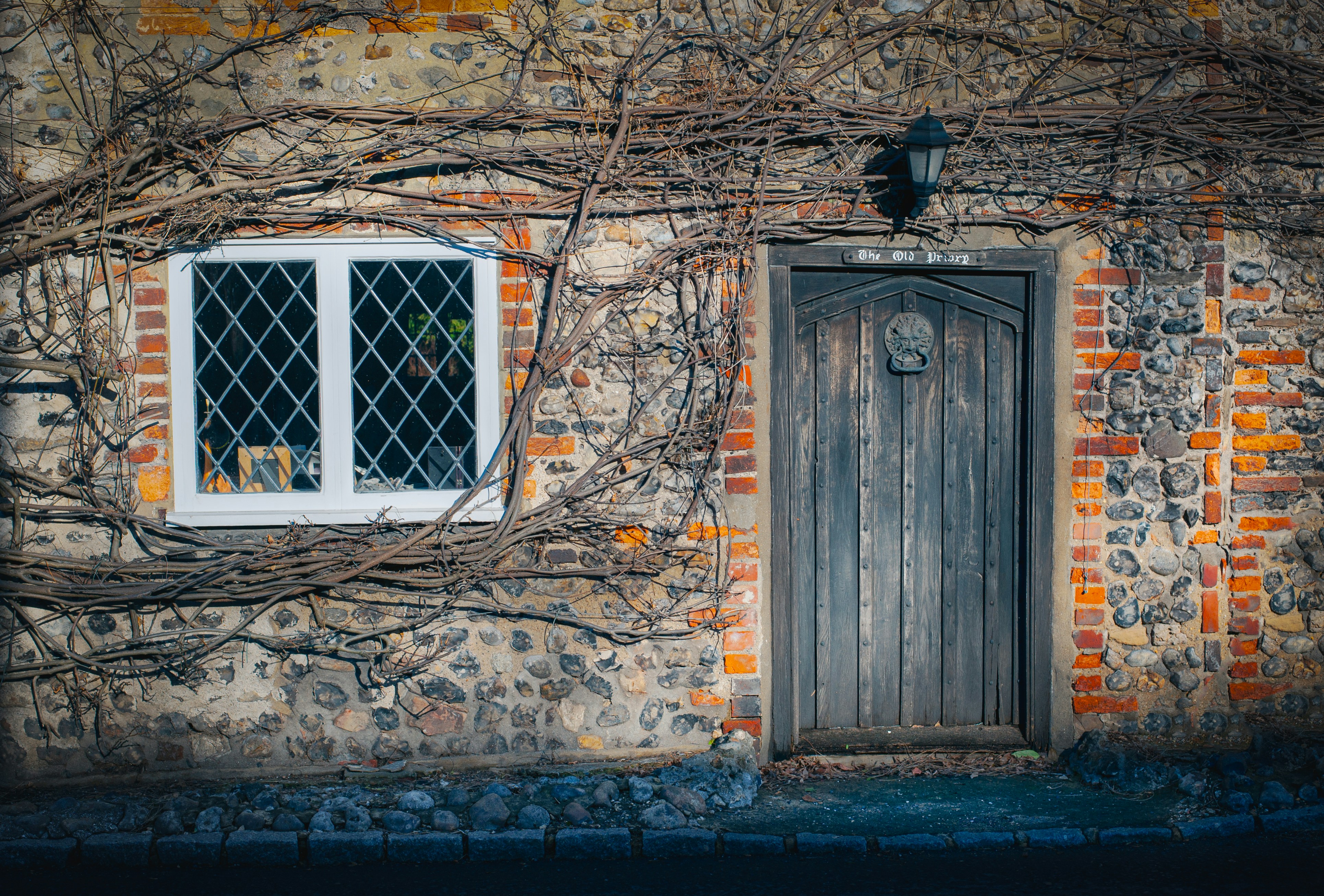 A brick building with a wooden door and window photo – Free Bramber ...