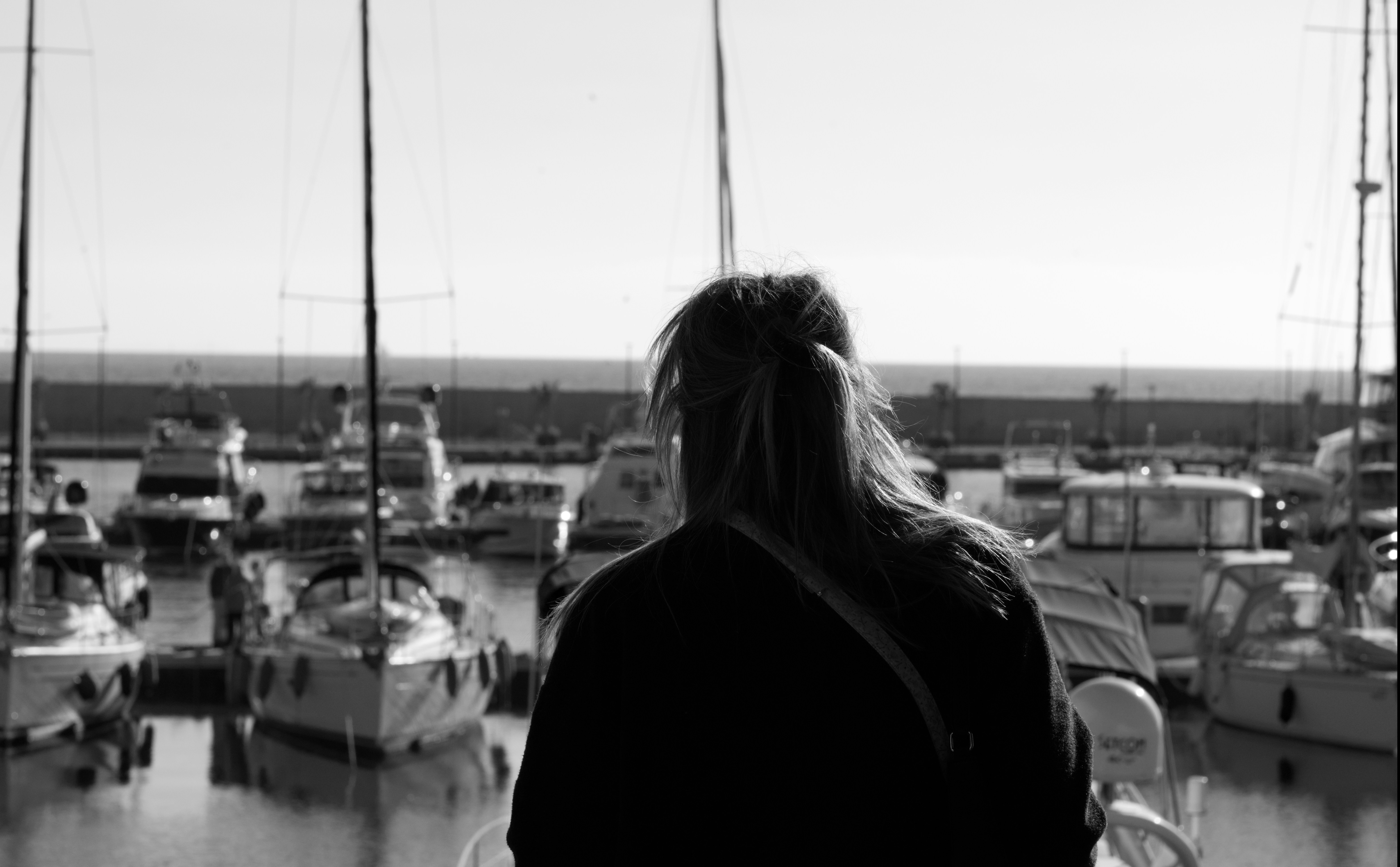 Harbor Silhouette: A Quiet Backview Among Stilled Sails