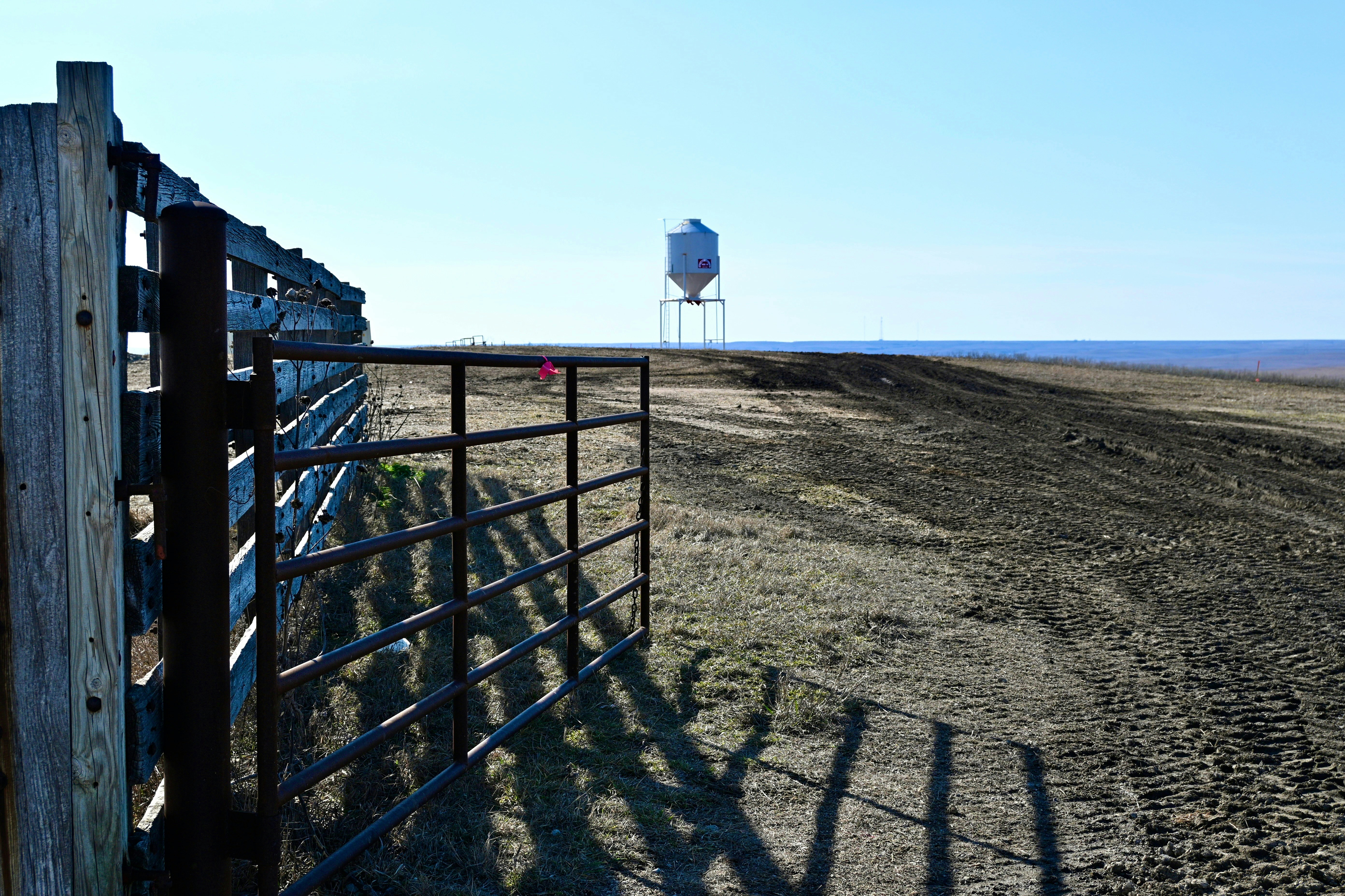 A fence with a water tower in the background photo – Free Outdoors ...