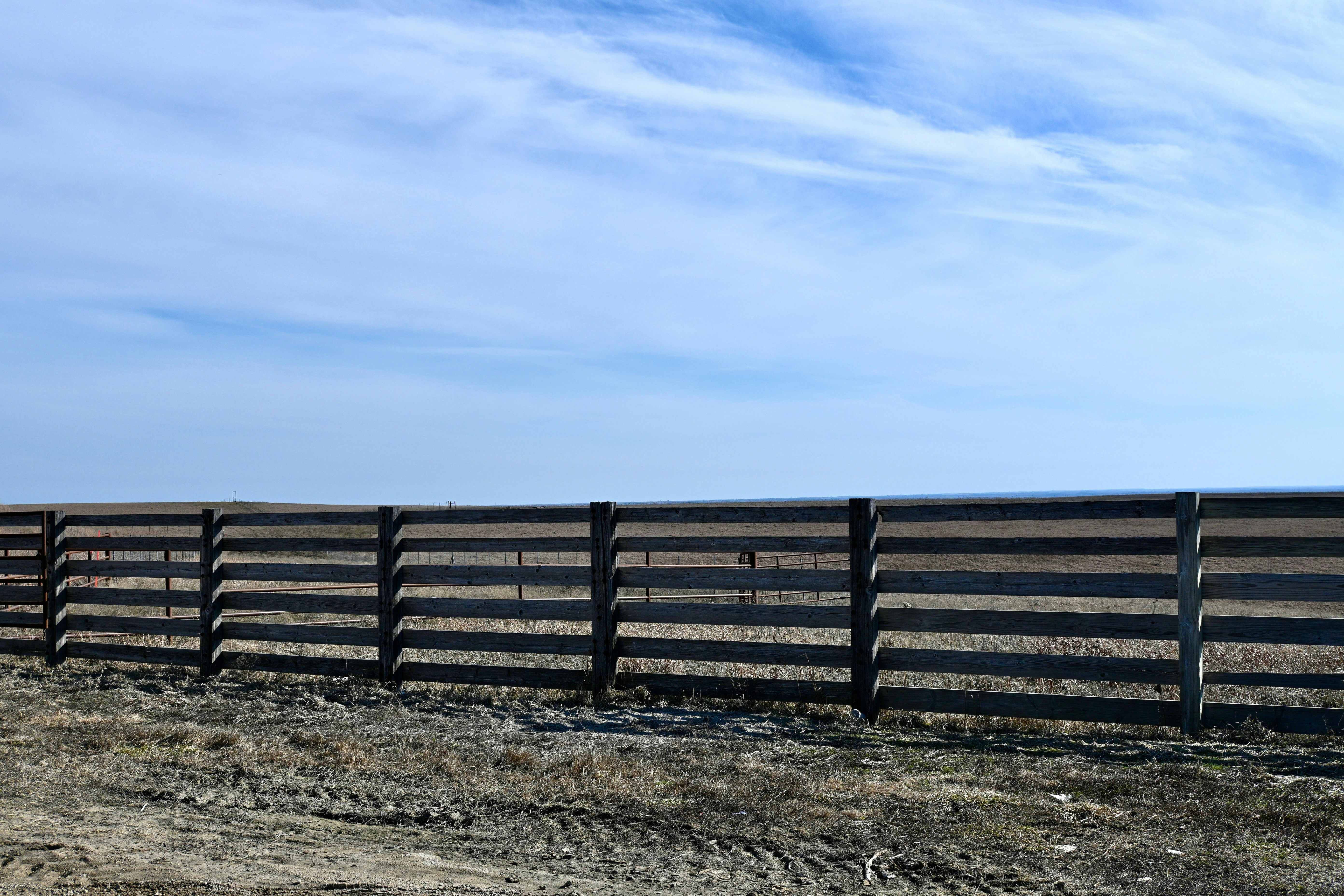 Weathered Slats: A Quiet Boundary Across the Dry Plain