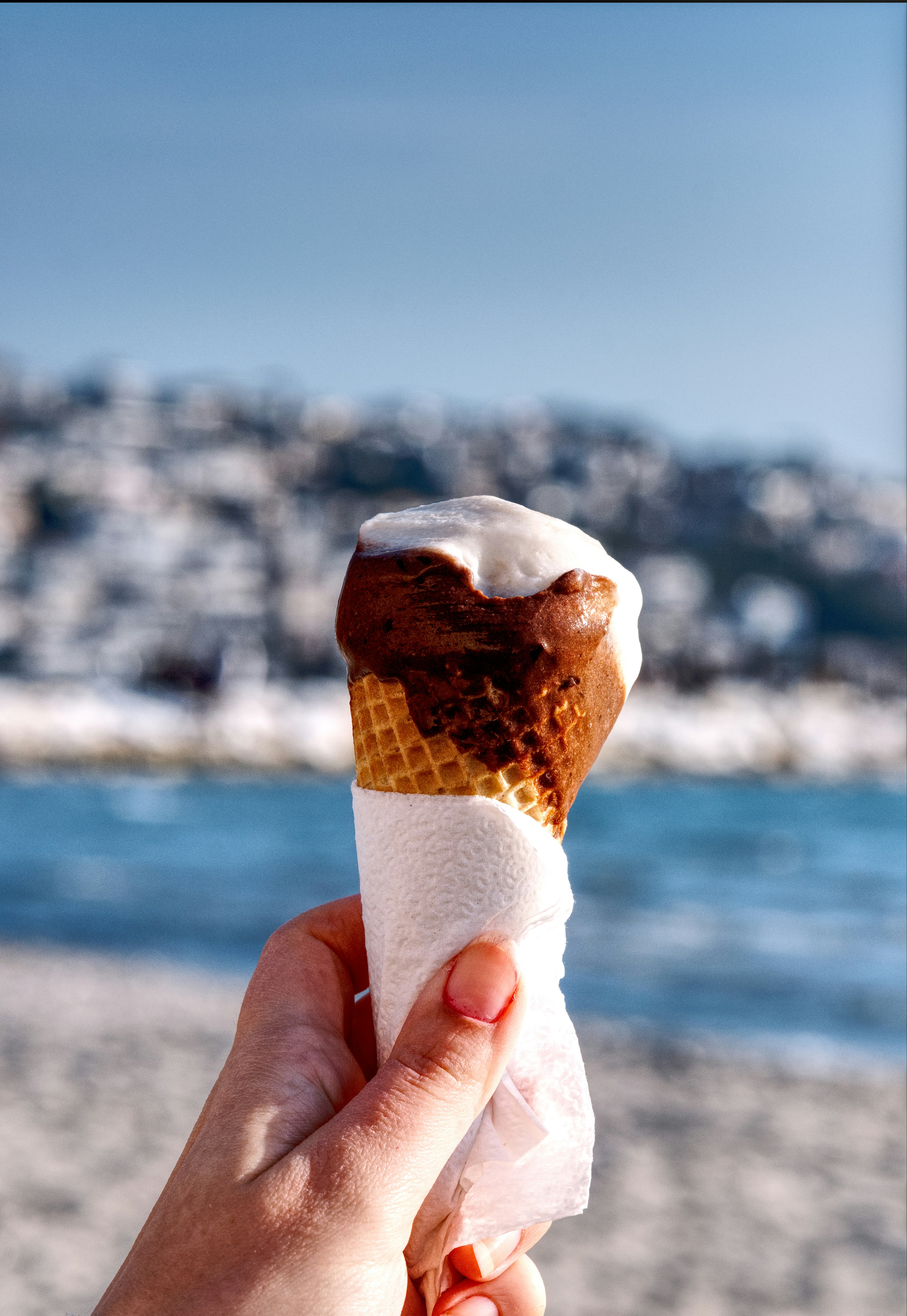 Seaside Cone in Focus: Handheld Treat at the Breakwater