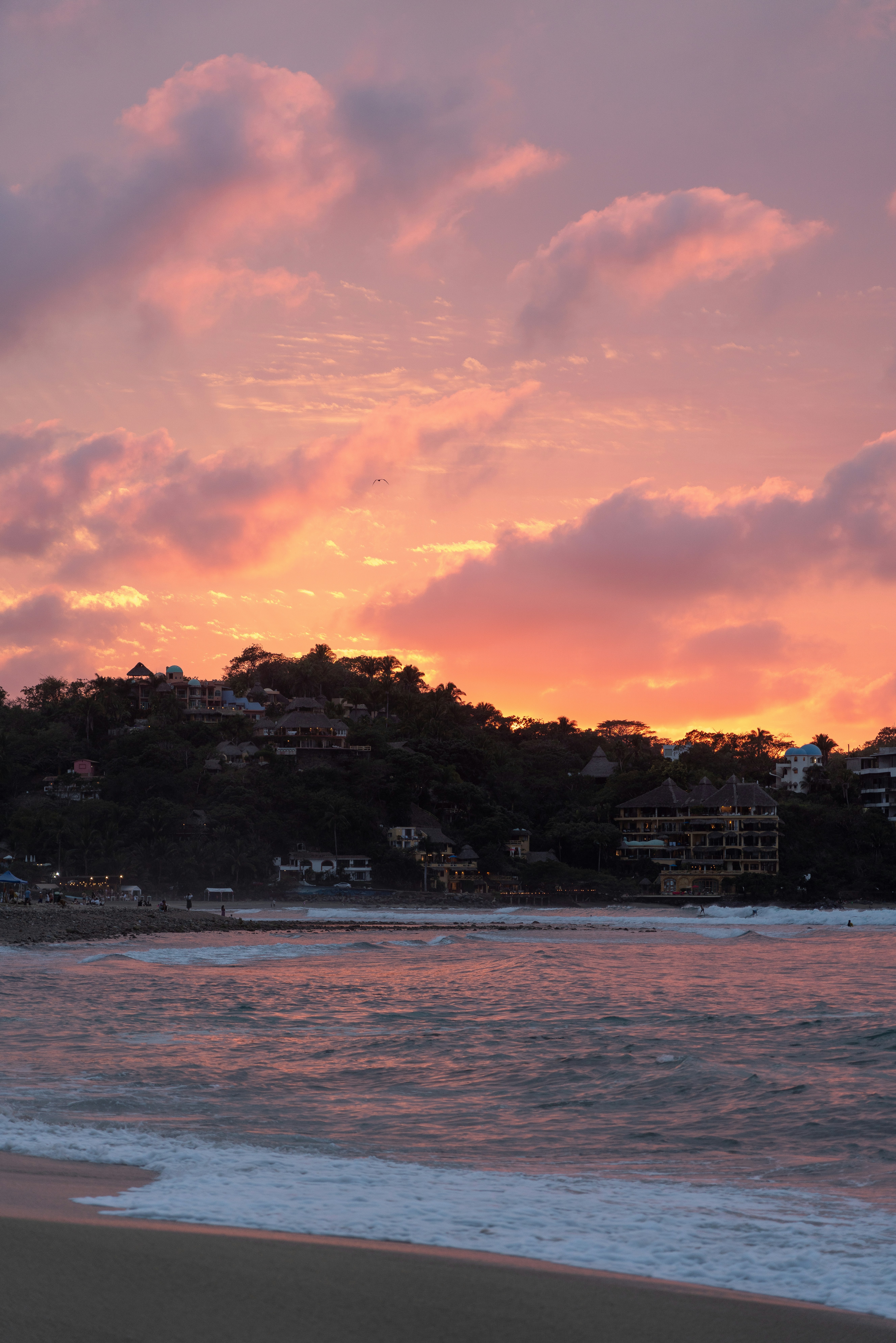 A sunset view of a beach with houses in the background photo – Free ...