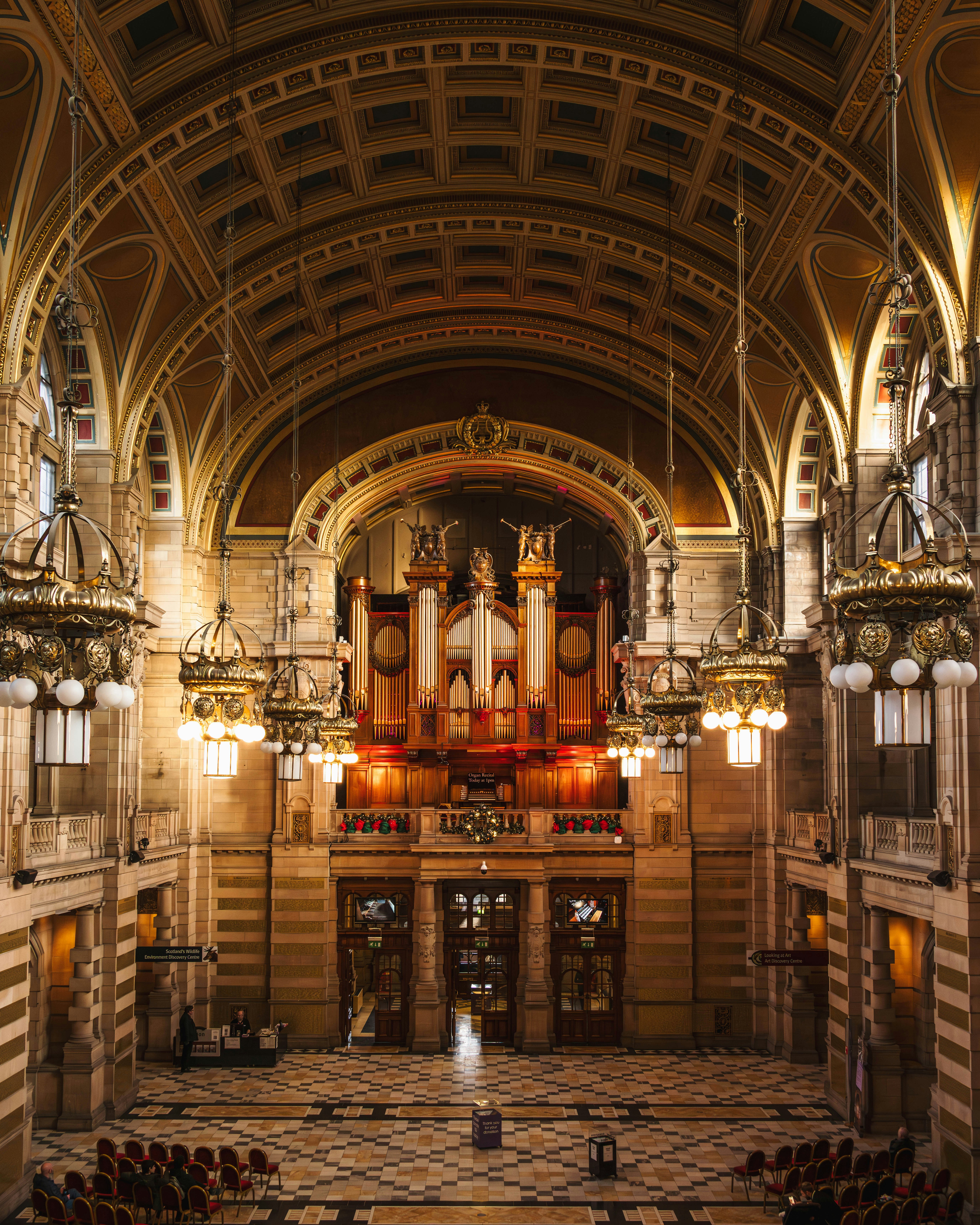 Opulent Symmetry: Organ Loft Beneath Gilded Arches in a Grand Hall