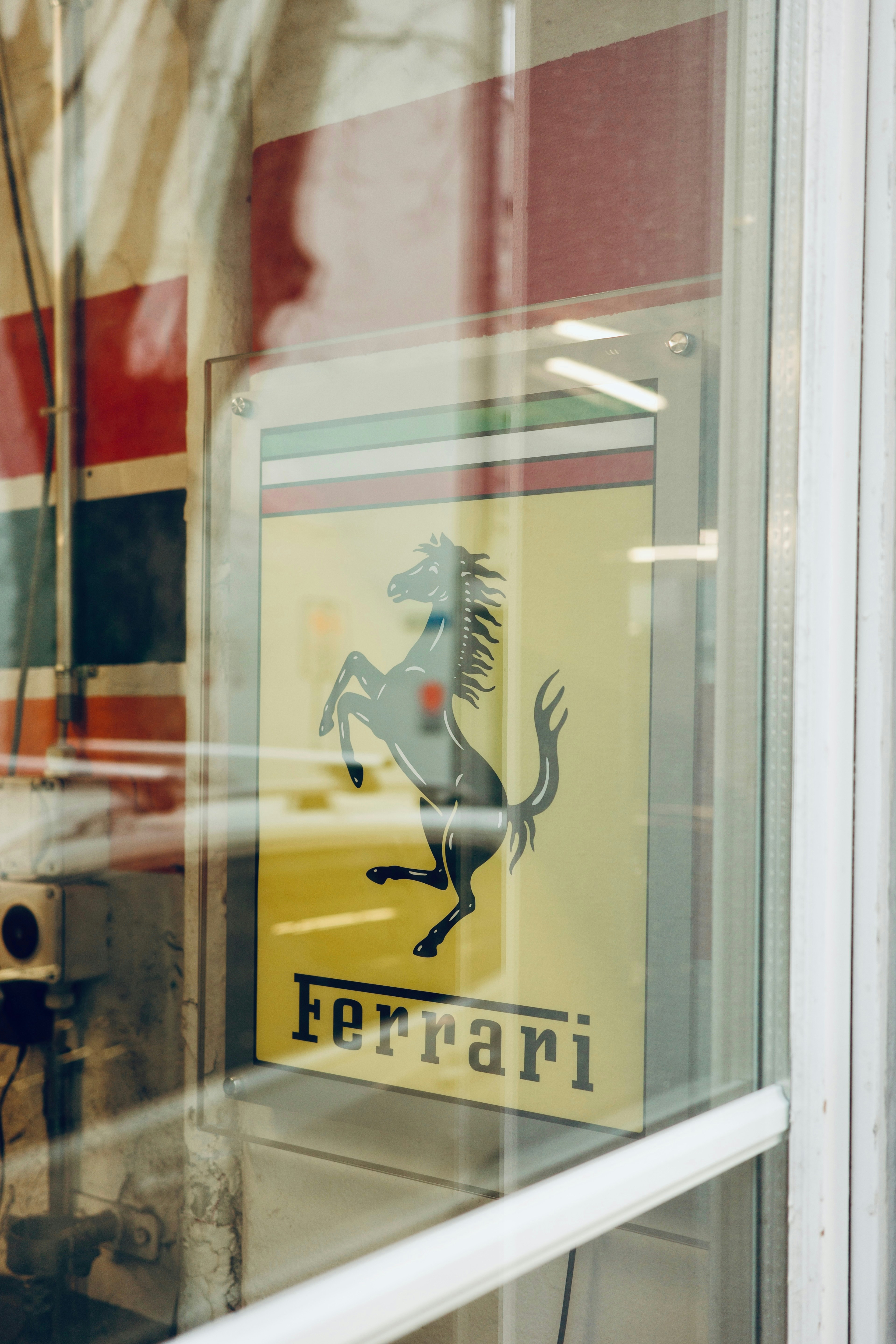 A ferrari logo is seen through a window photo – Free Switzerland Image ...