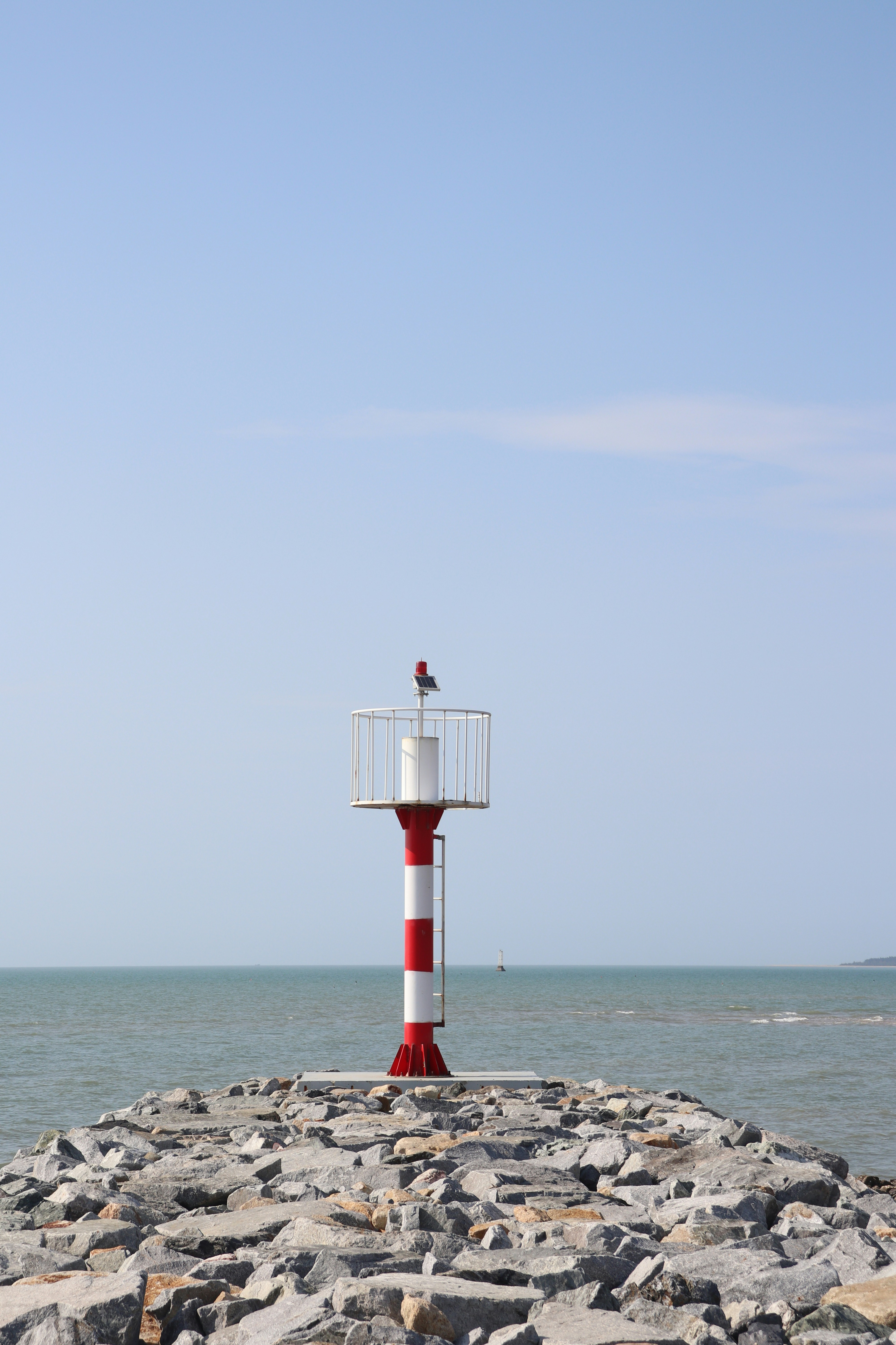 Red and White Beacon Stands Against the Quiet Sea