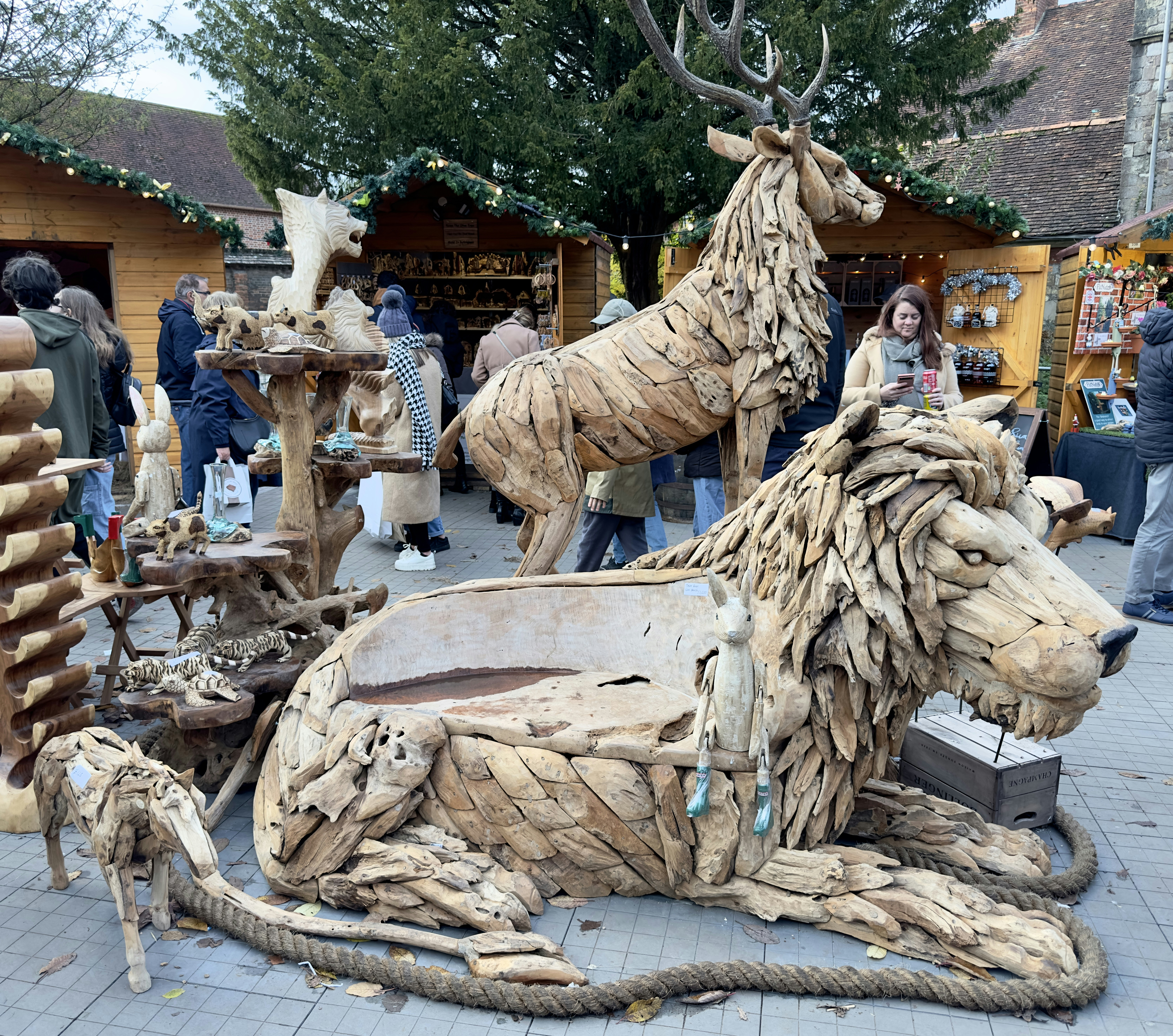 Timber Titan at the Market: A Reclining Wooden Beast Amid Craft Stalls