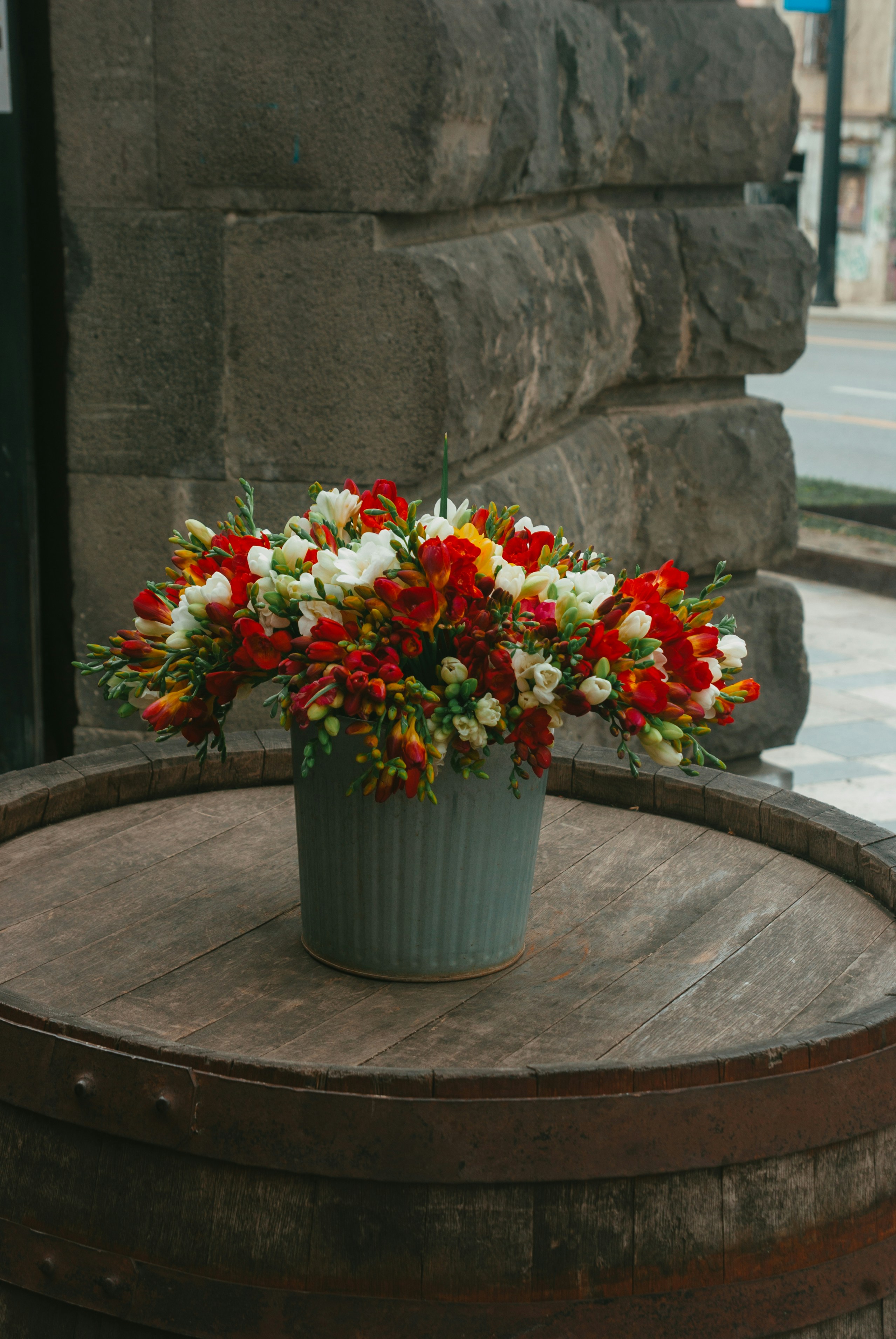 Scarlet and Ivory Bouquet on a Weathered Barrel