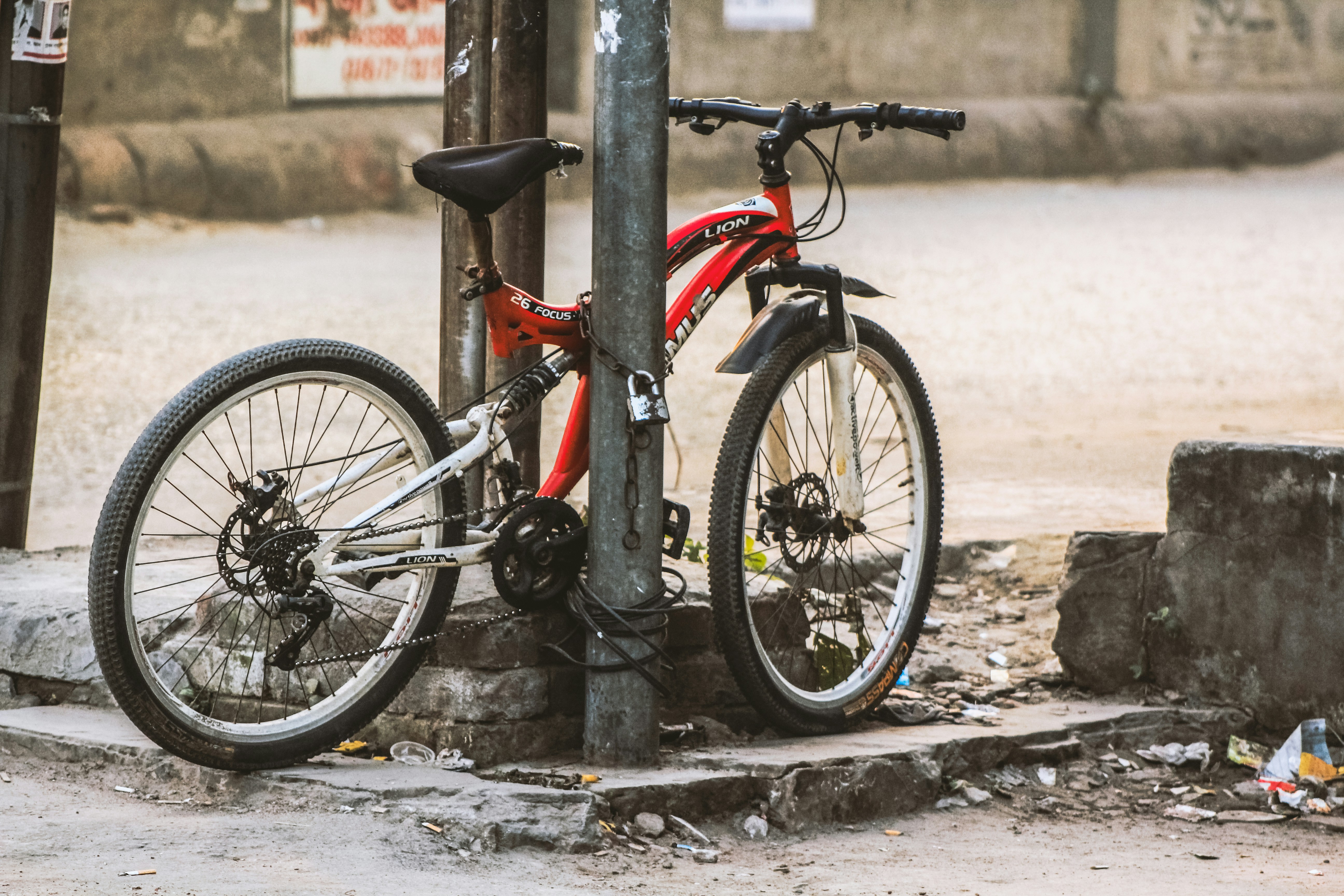 A bicycle is chained up to a pole photo – Free Dual suspension cycle ...