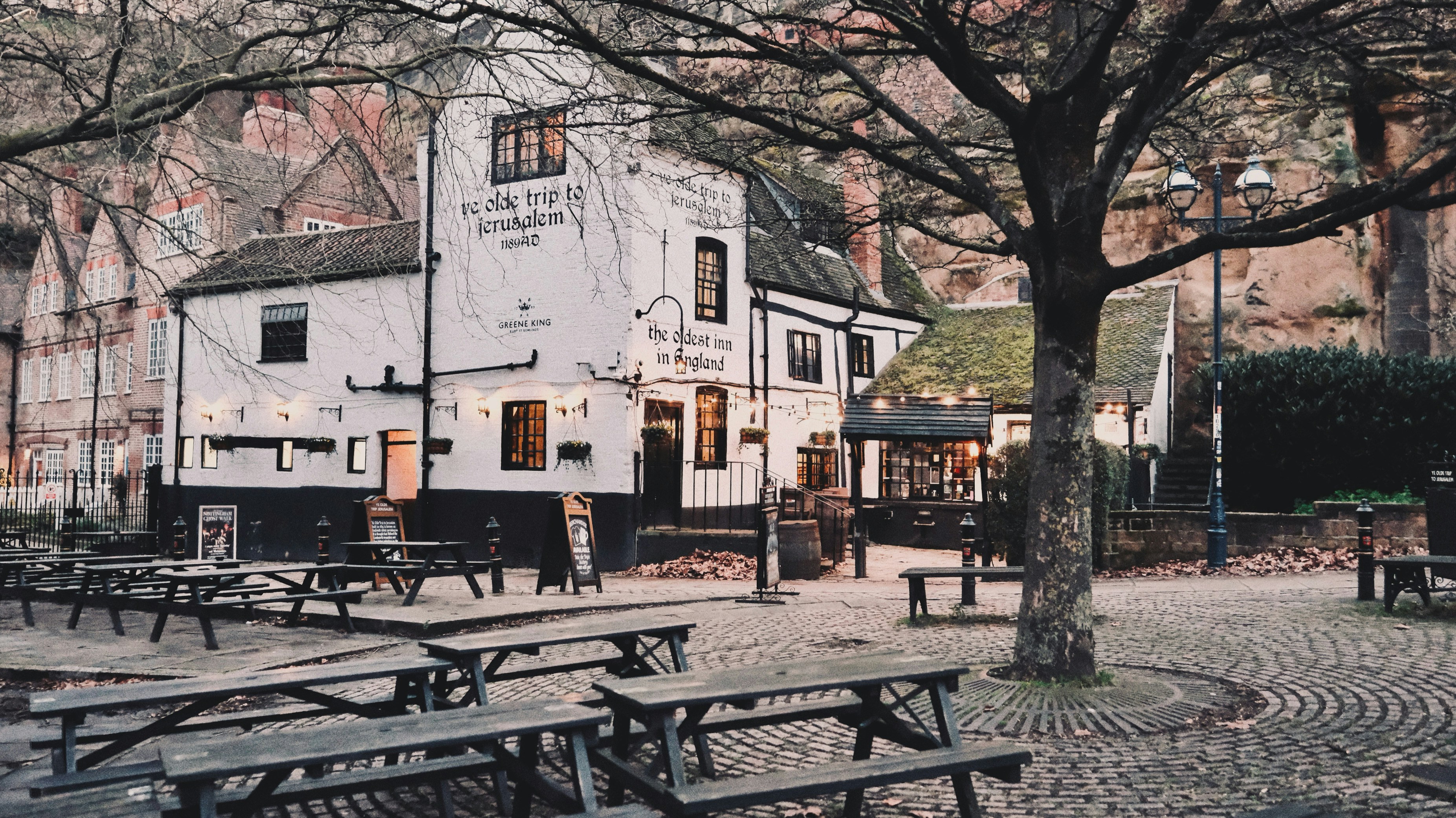 A group of benches sitting in front of a building photo – Free ...