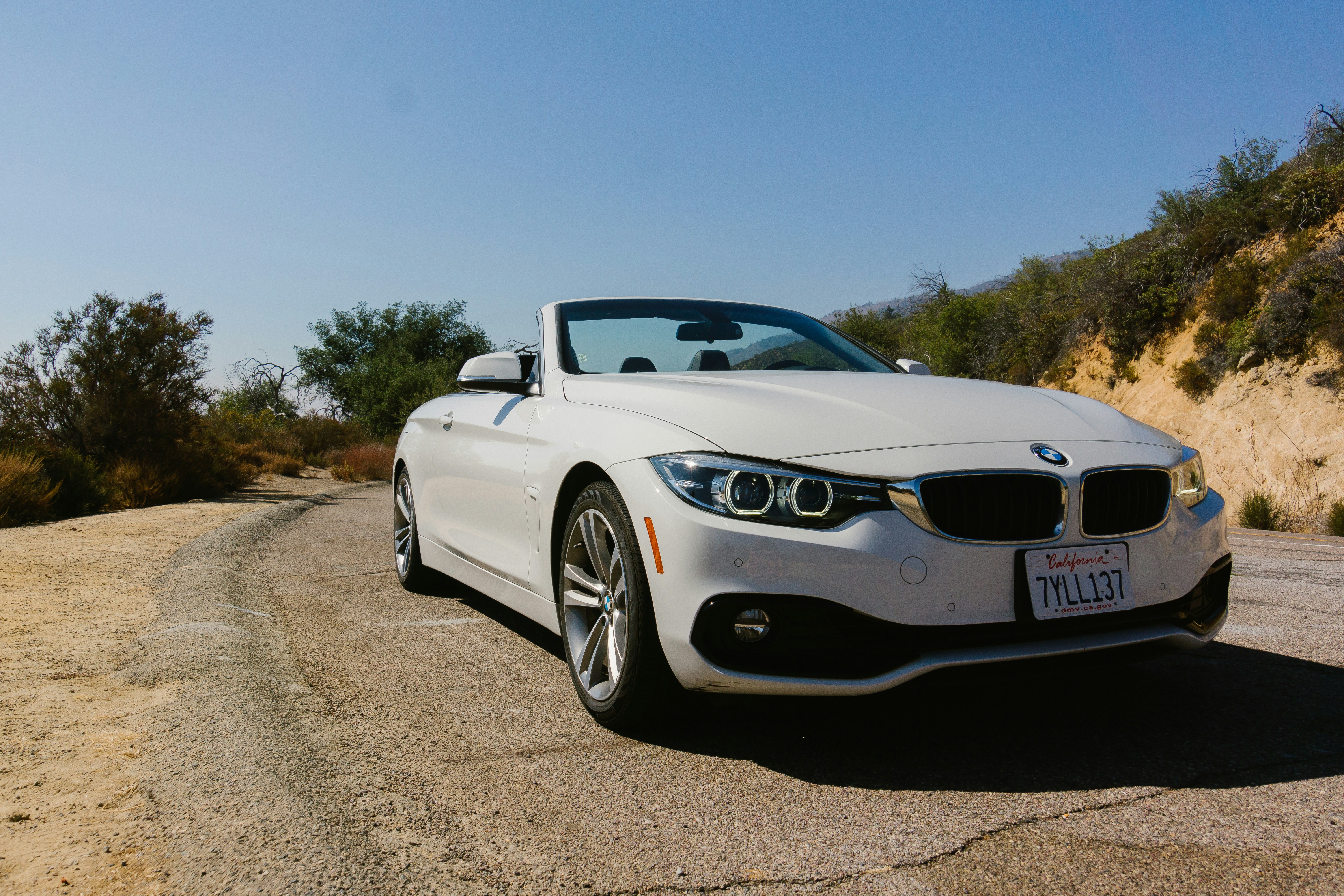 White BMW on a Desert Road — Sunlit Curves and Open Sky