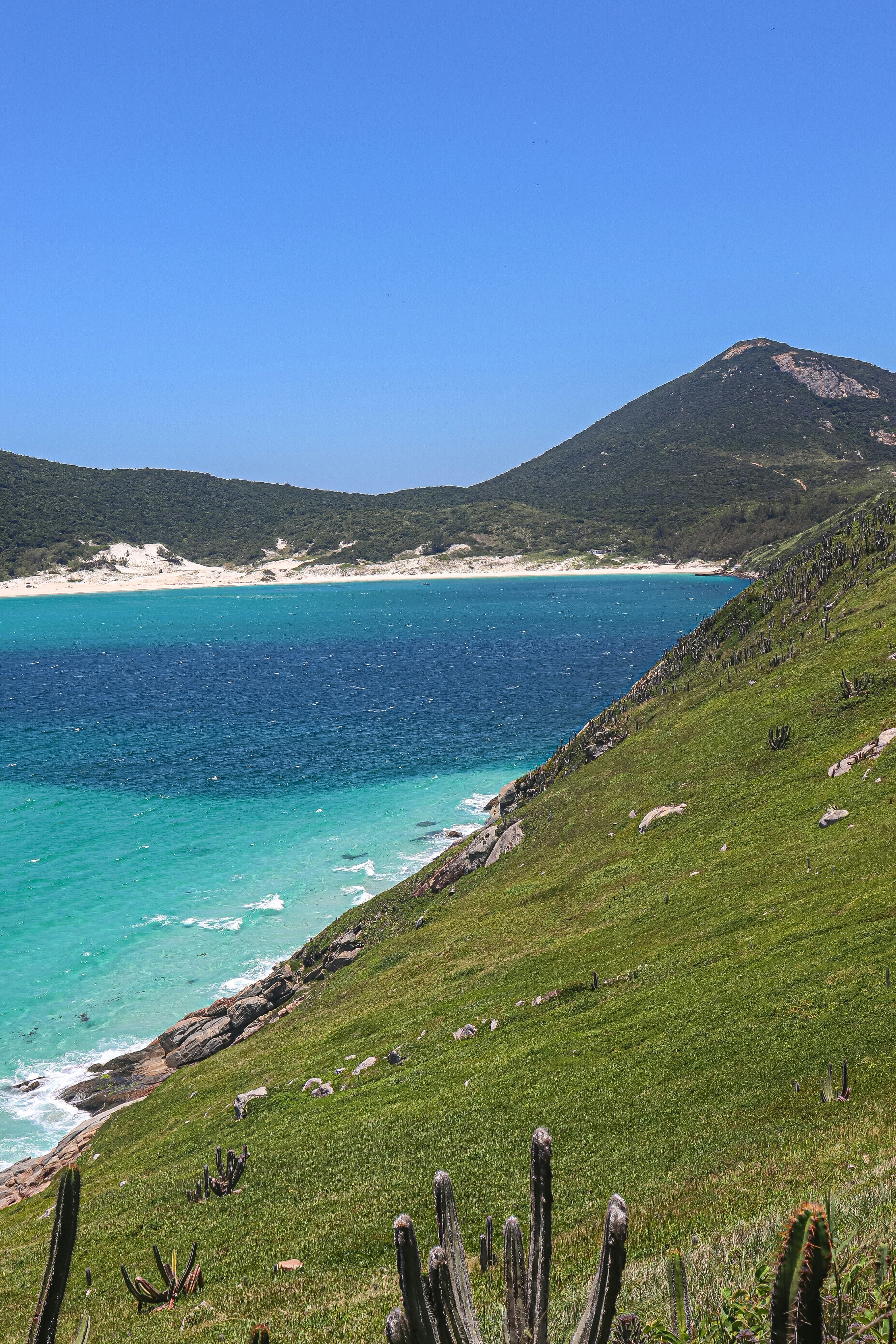 A large body of water sitting next to a lush green hillside photo ...