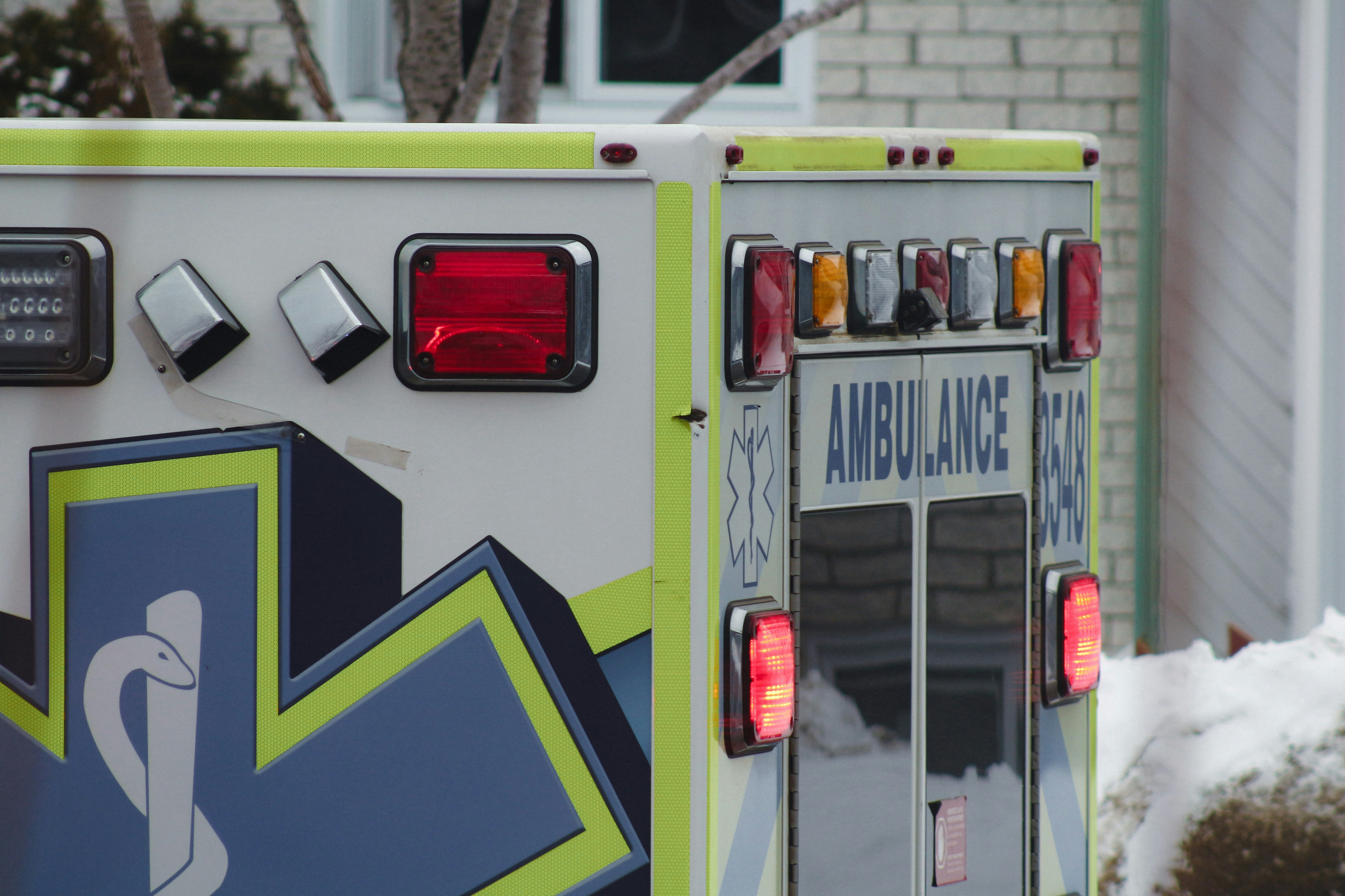 An ambulance parked in front of a house in the snow photo – Free ...