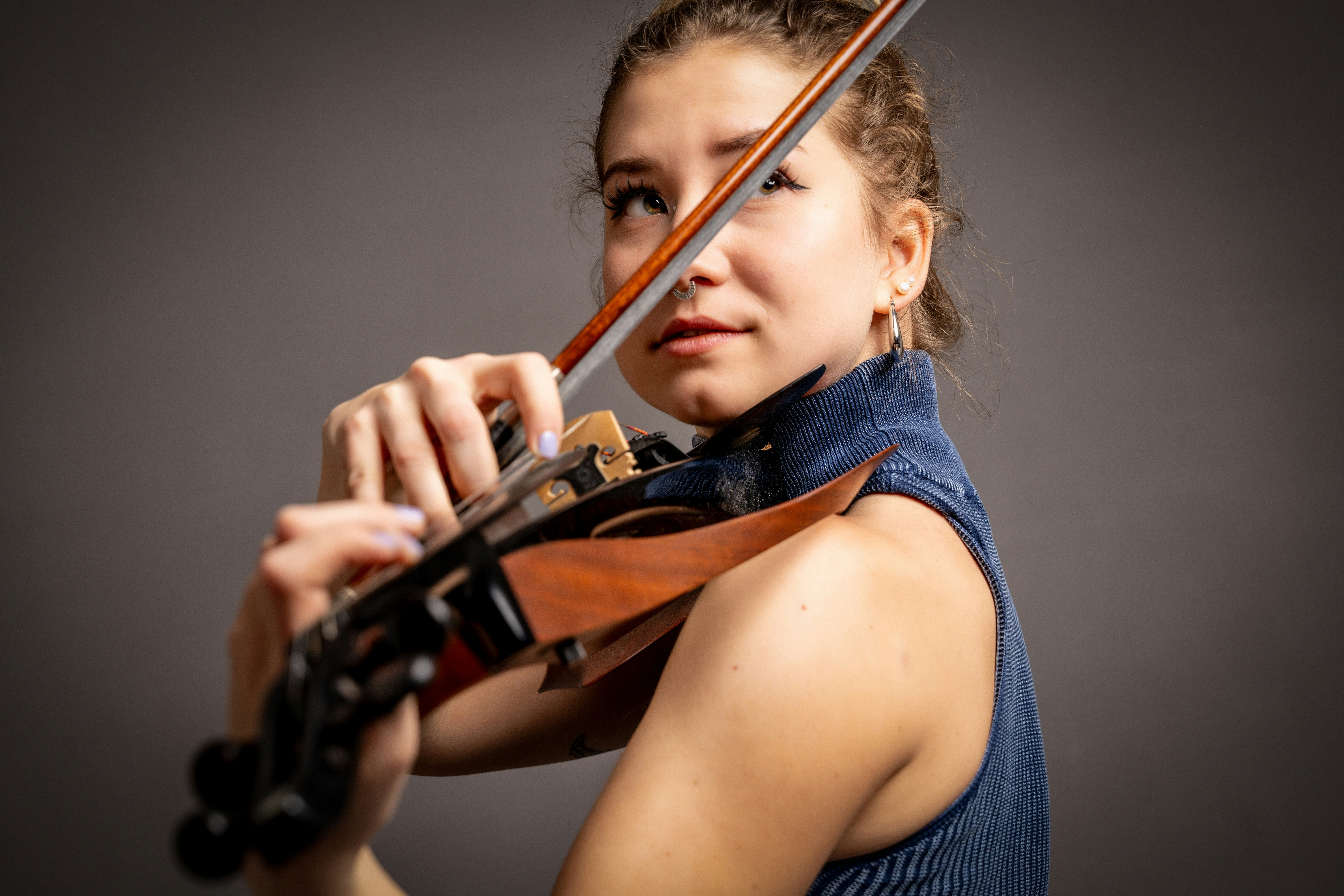 A young woman holding a violin in her right hand photo – Free Electric ...