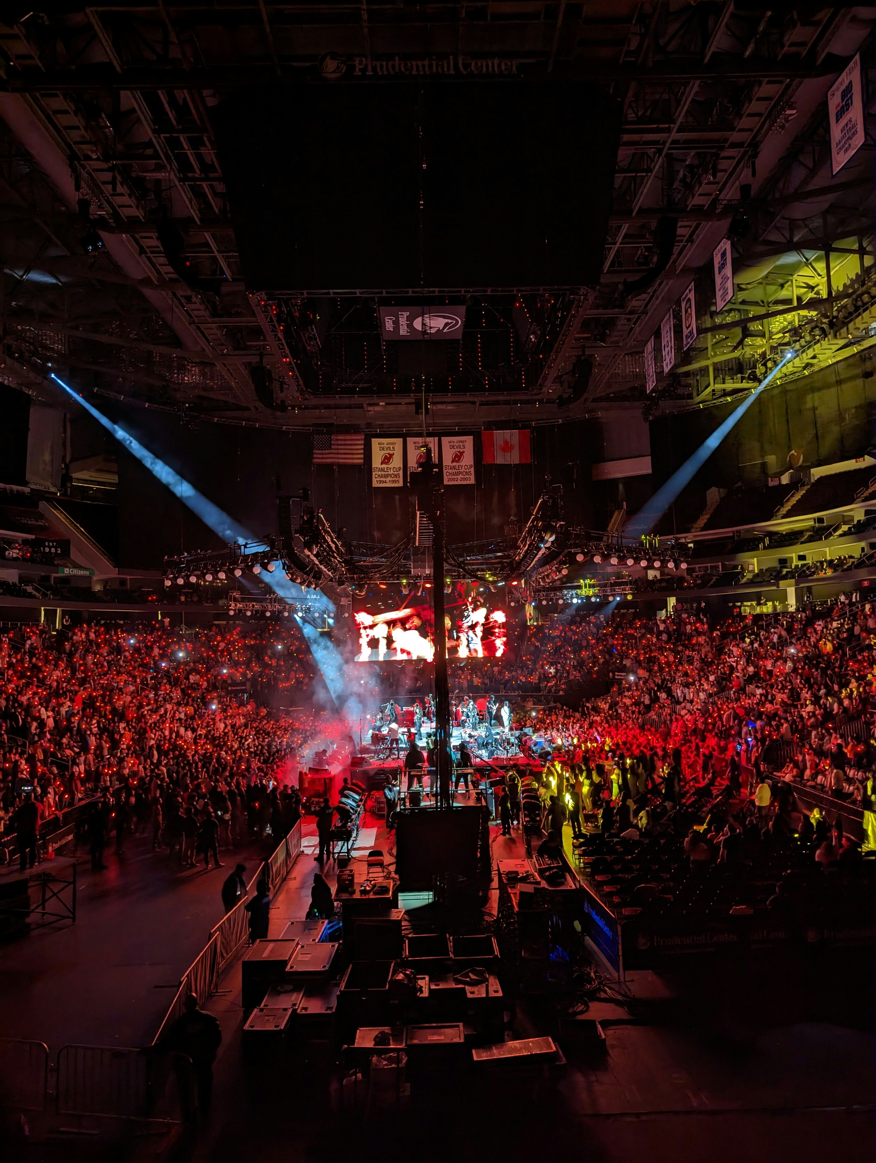 Stage Halo in a Sea of Fans: Red and Blue Beams Illuminate the Arena
