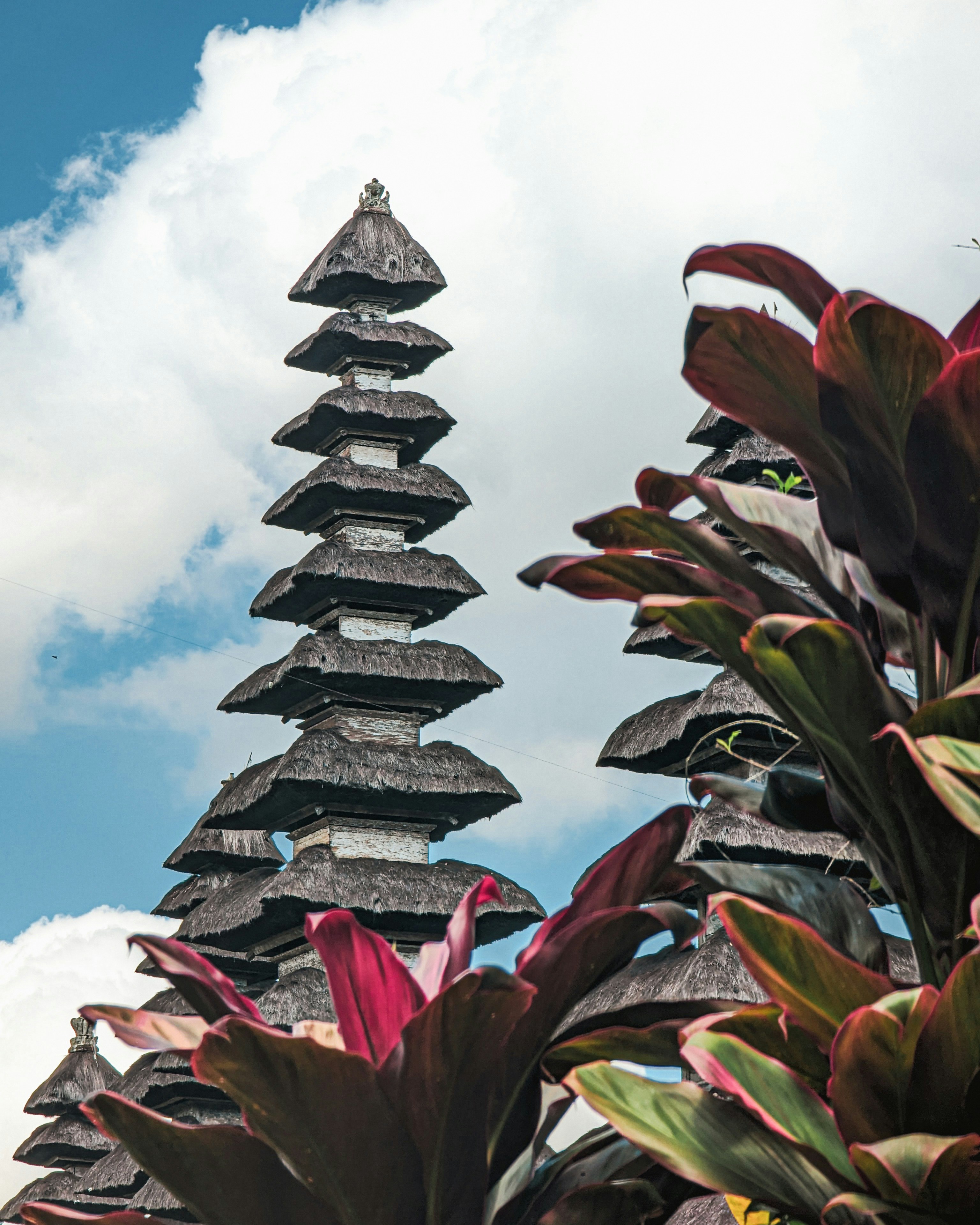 Tiered Stone Pagoda Rising Under a Bright Sky, Framed by Crimson Foliage