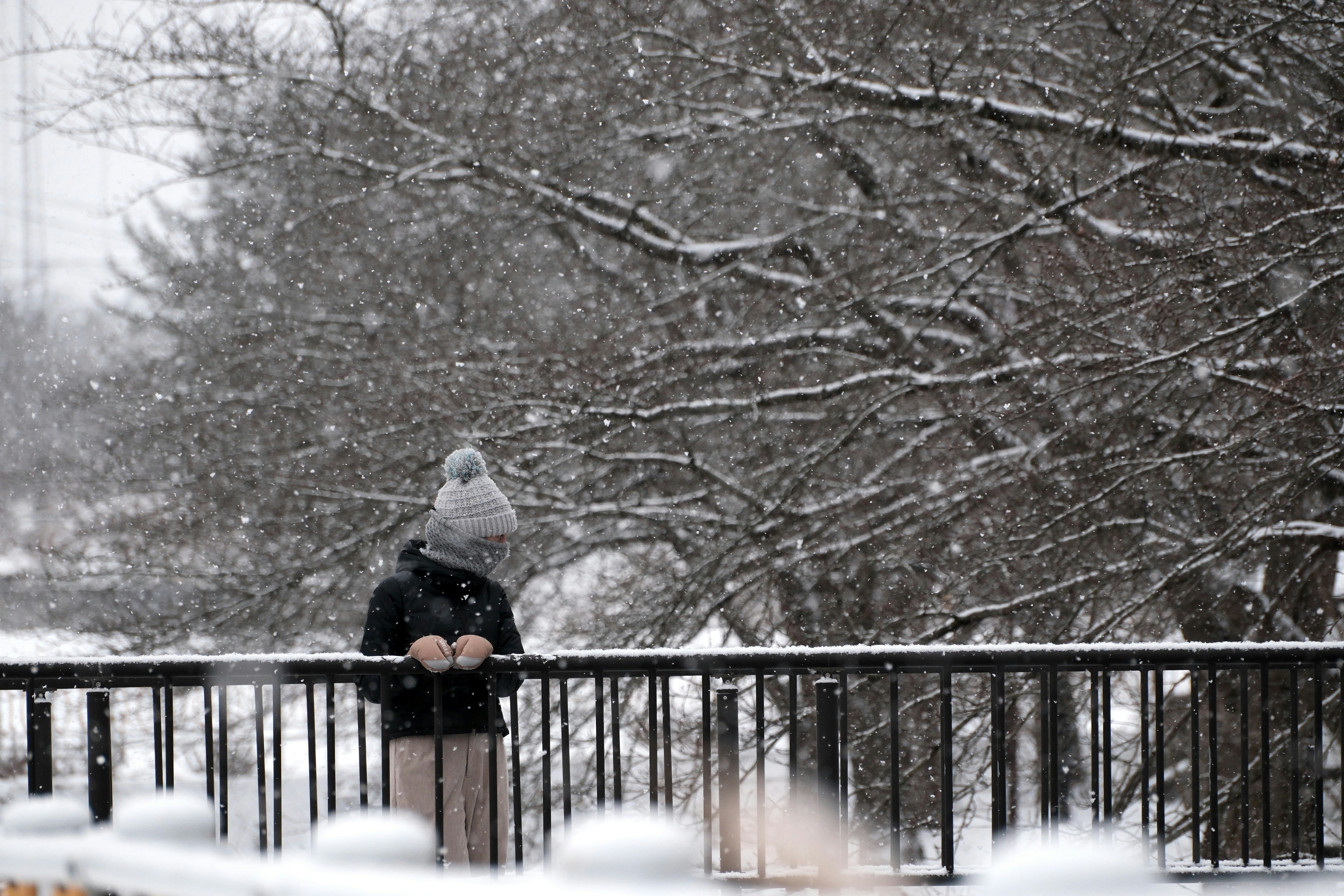 Silent Figure by a Snow-Dusted Balcony Rail