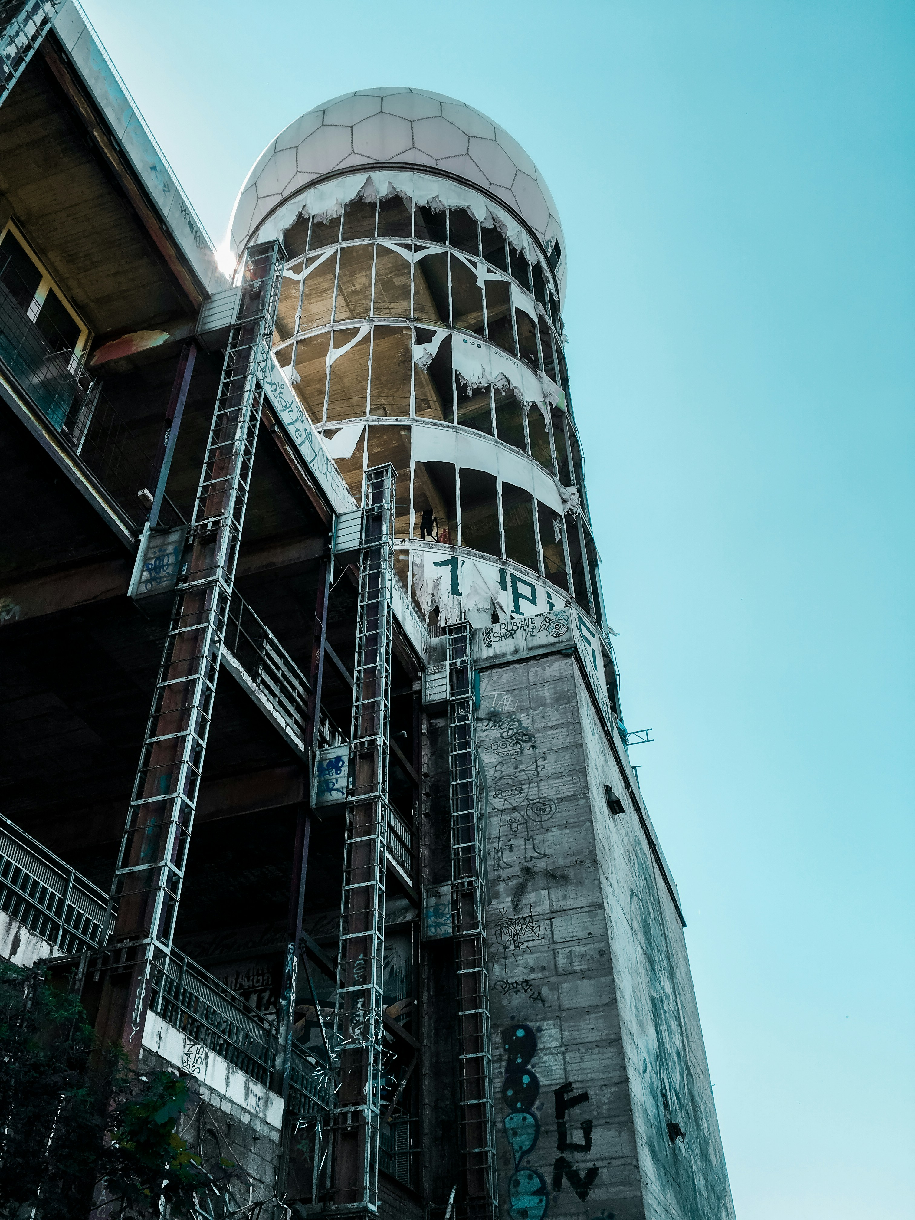 Industrial beacon rising from a weathered concrete facade