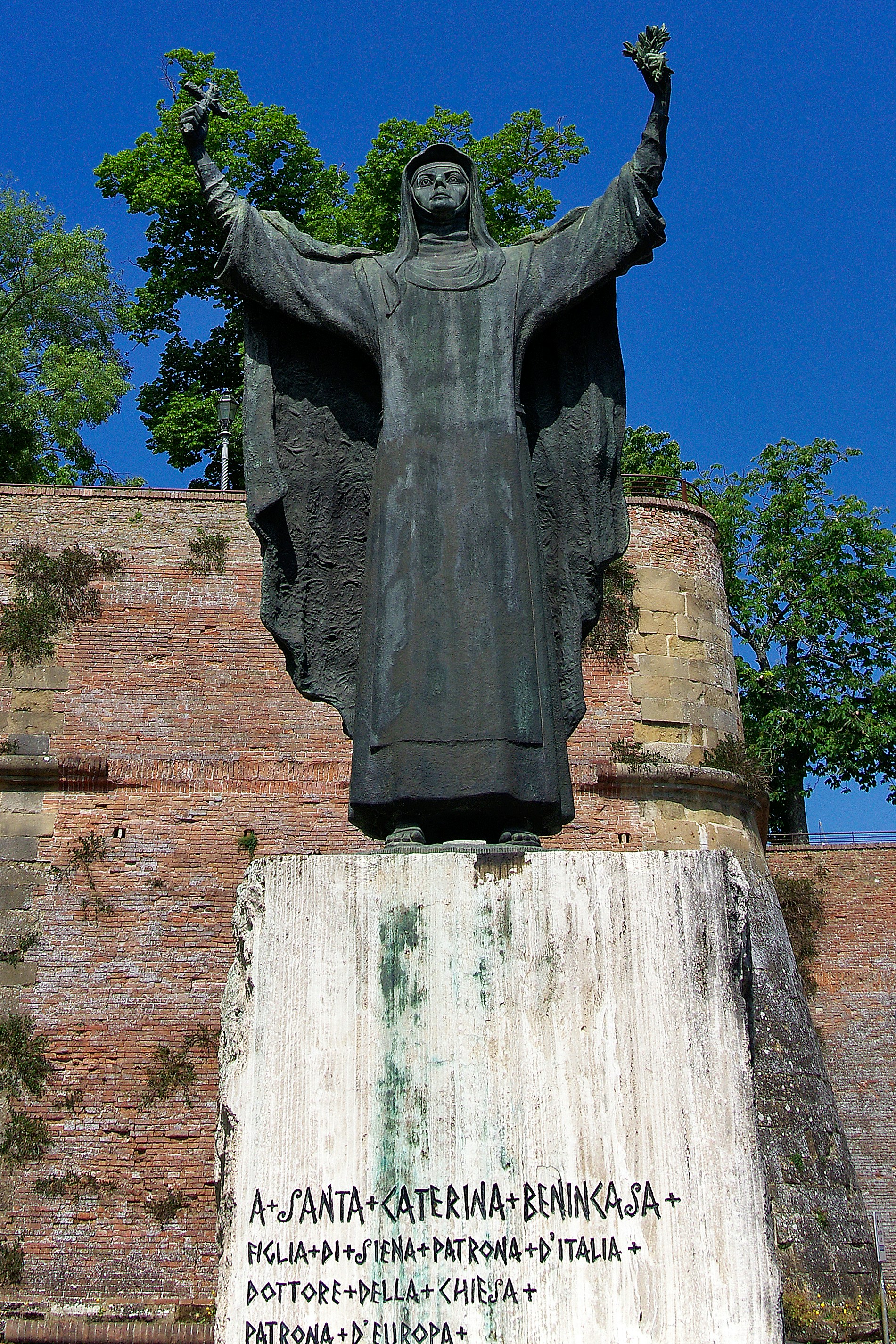 Arms Wide to the Sky: Bronze Saint on a Graffitied Pedestal