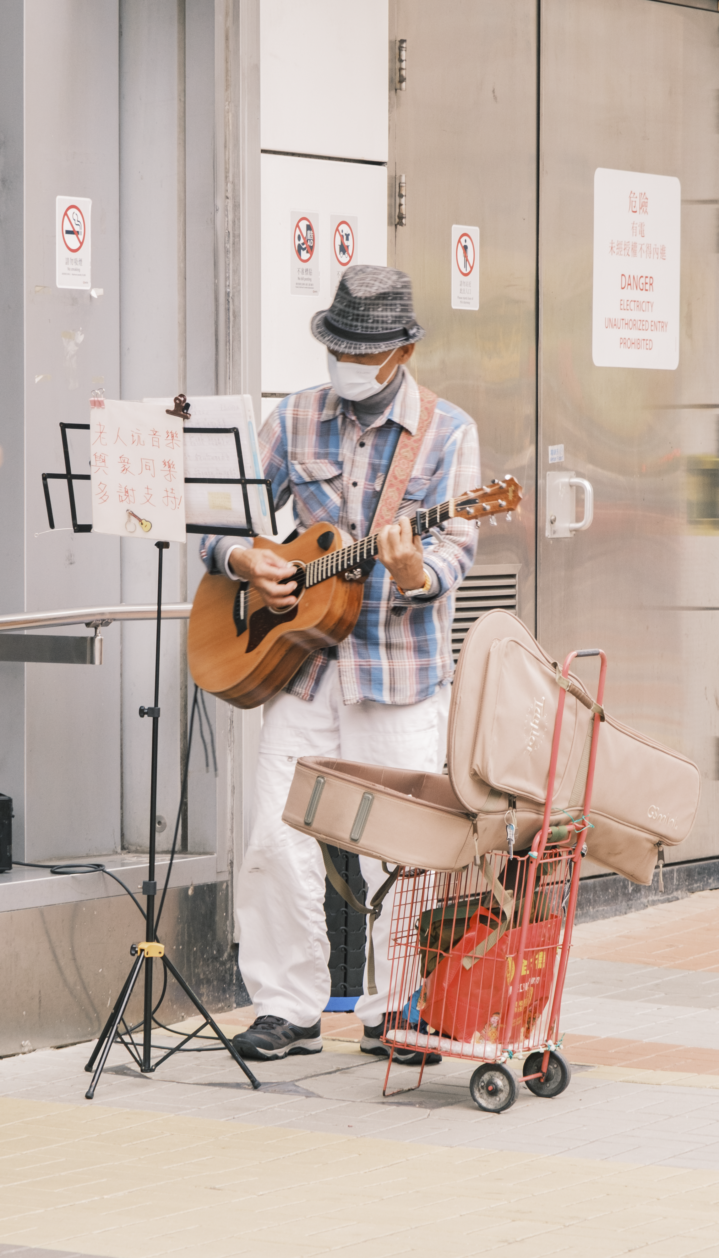 a man with a guitar and a shopping cart