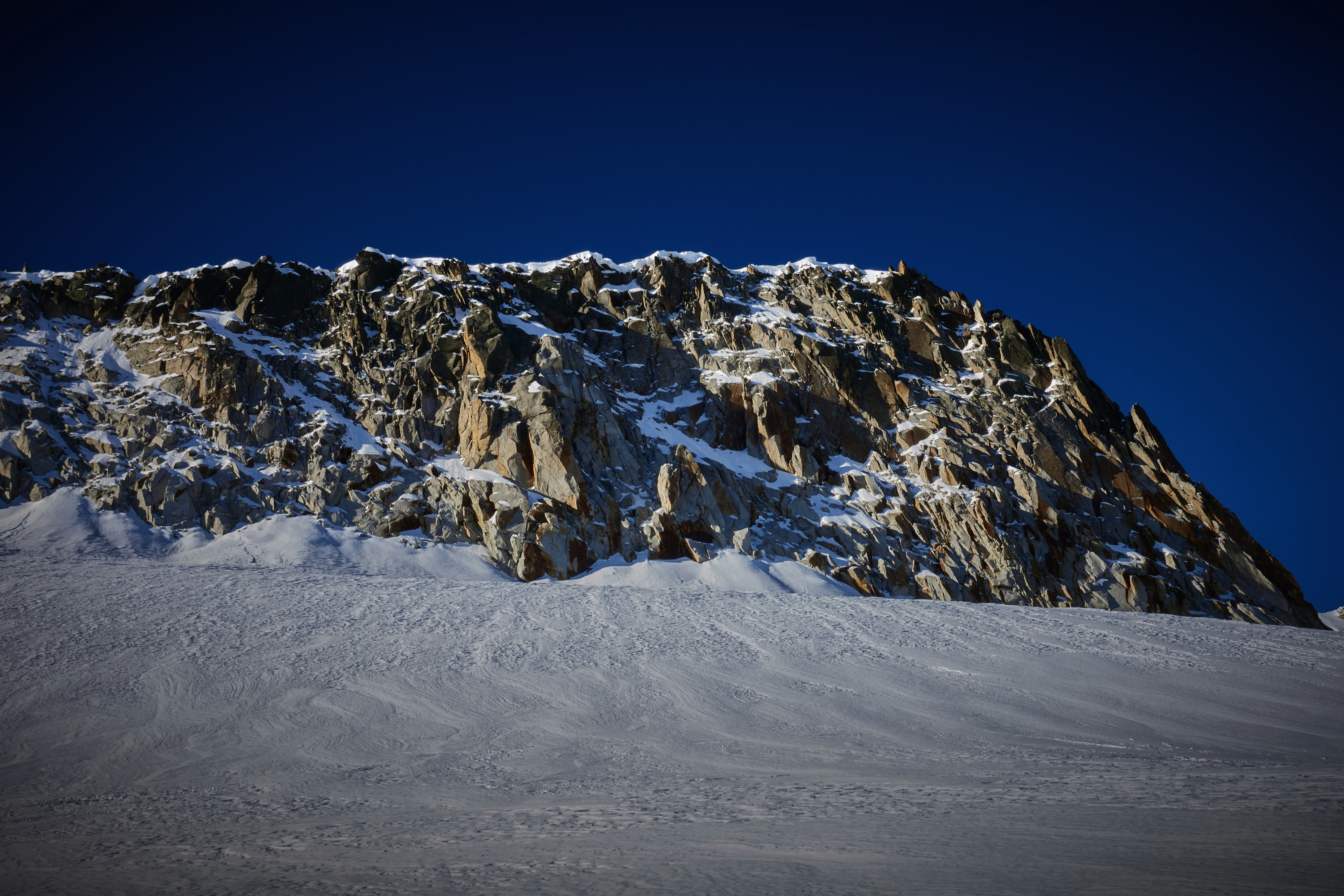 Una gran montaña cubierta de nieve bajo un cielo azul foto – Imagen de ...