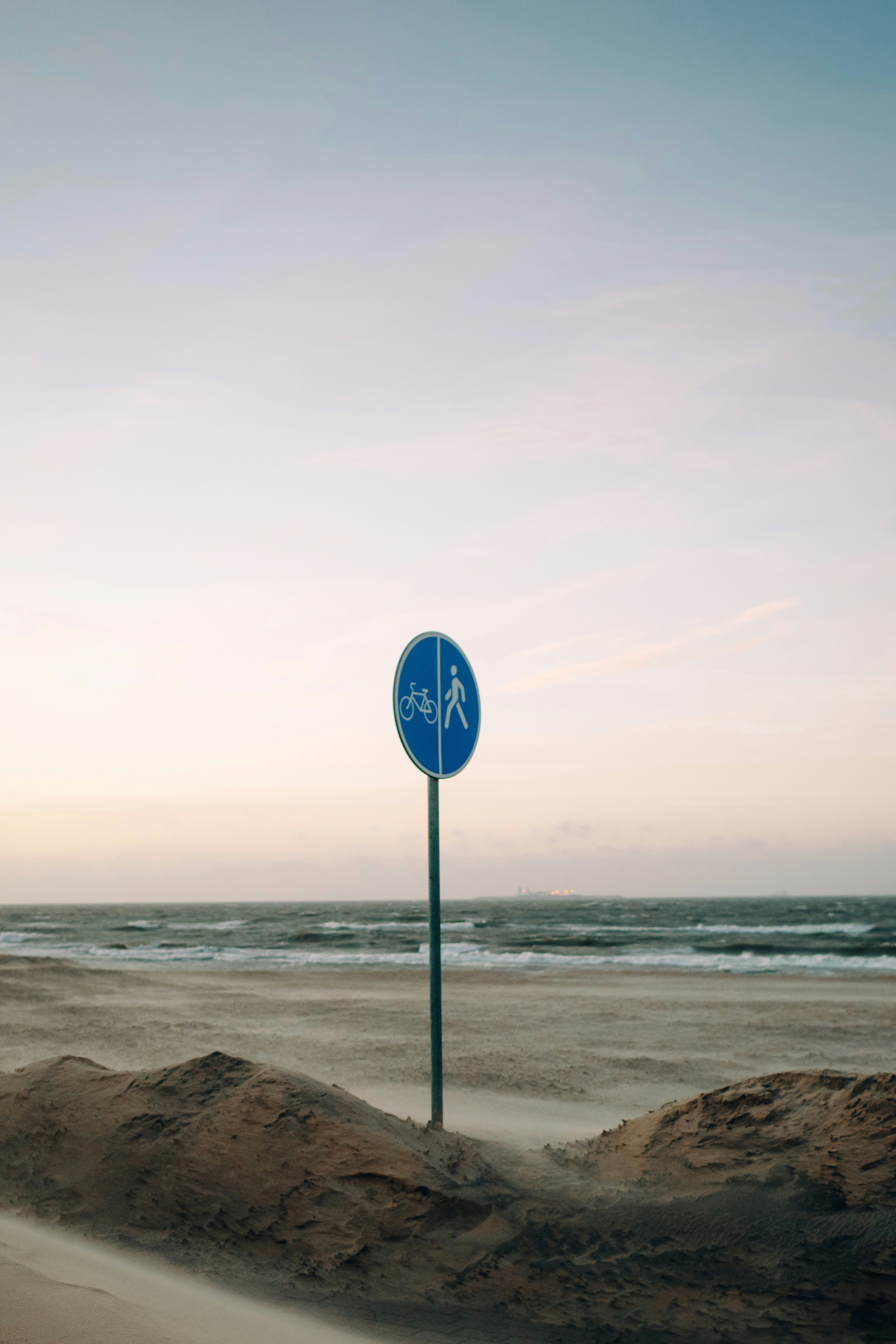 Blue Sign at the Shore: A Quiet Sentinel Over Sand and Sea
