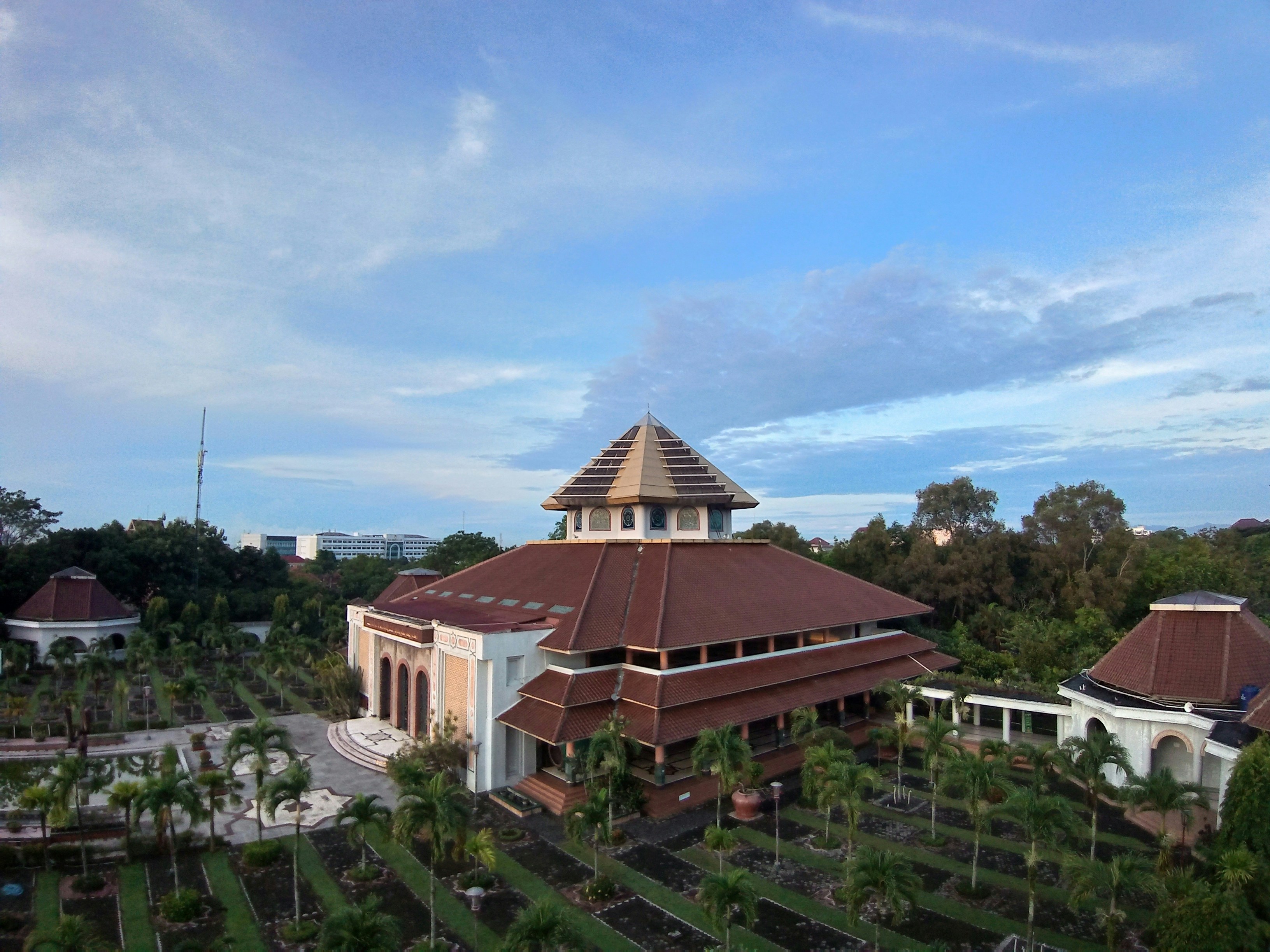 Tiered-Roof Campus Hall Rises Over a Palm-Lined Quad