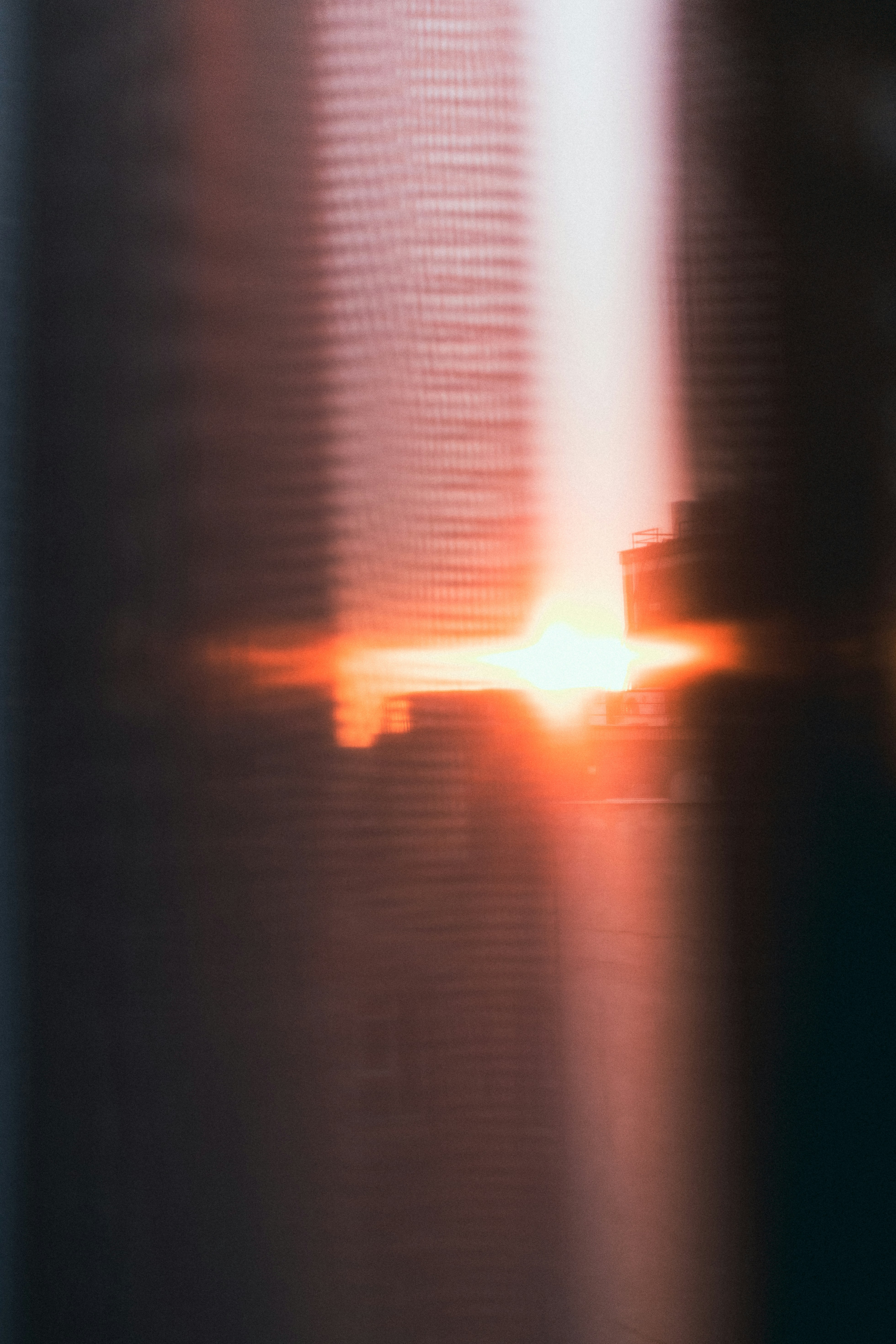 Solar flare through window blinds: a vertical glow over silhouettes