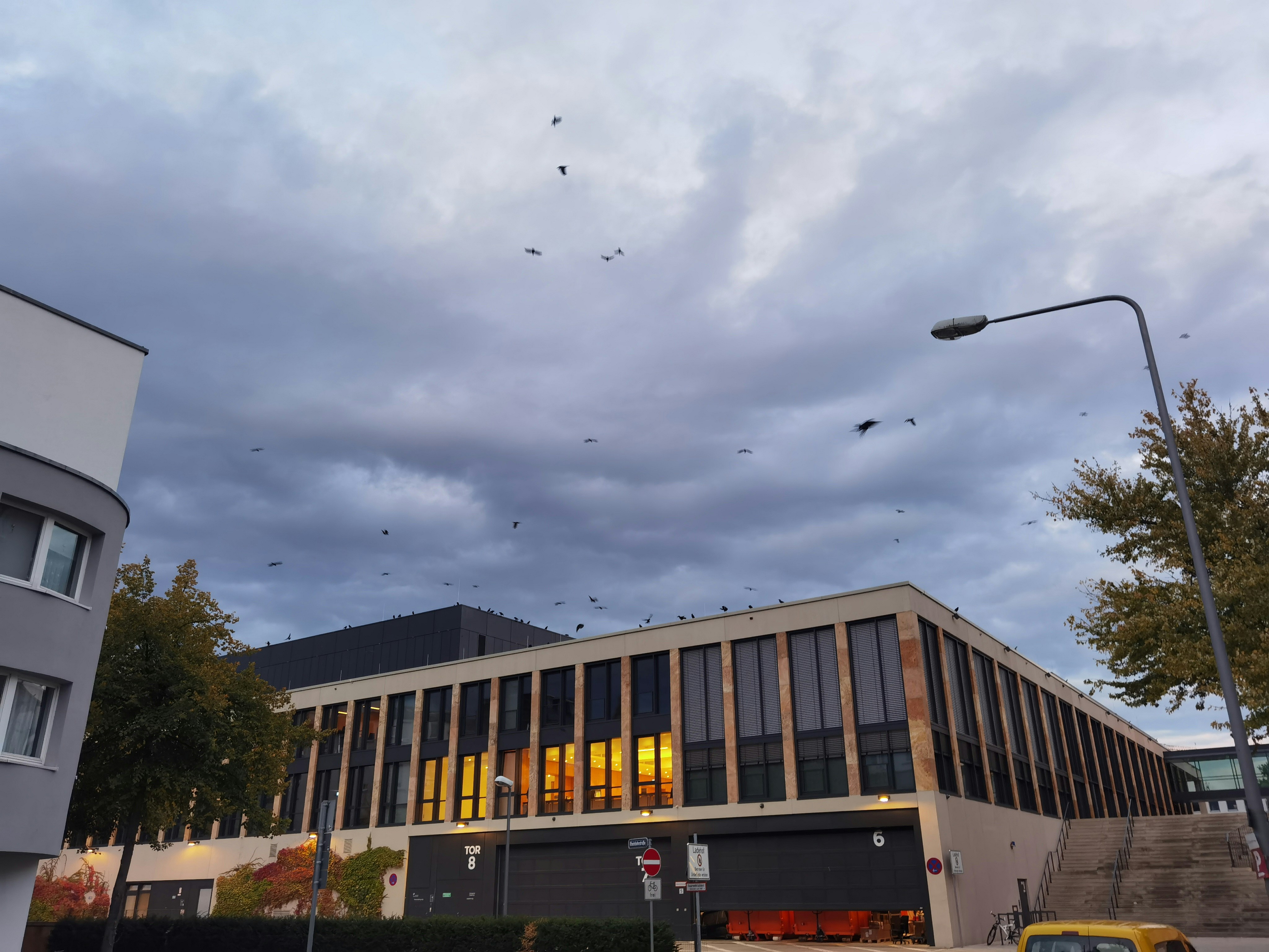 Amber Glow Across a Modern Campus Building Beneath a Ruffled Sky