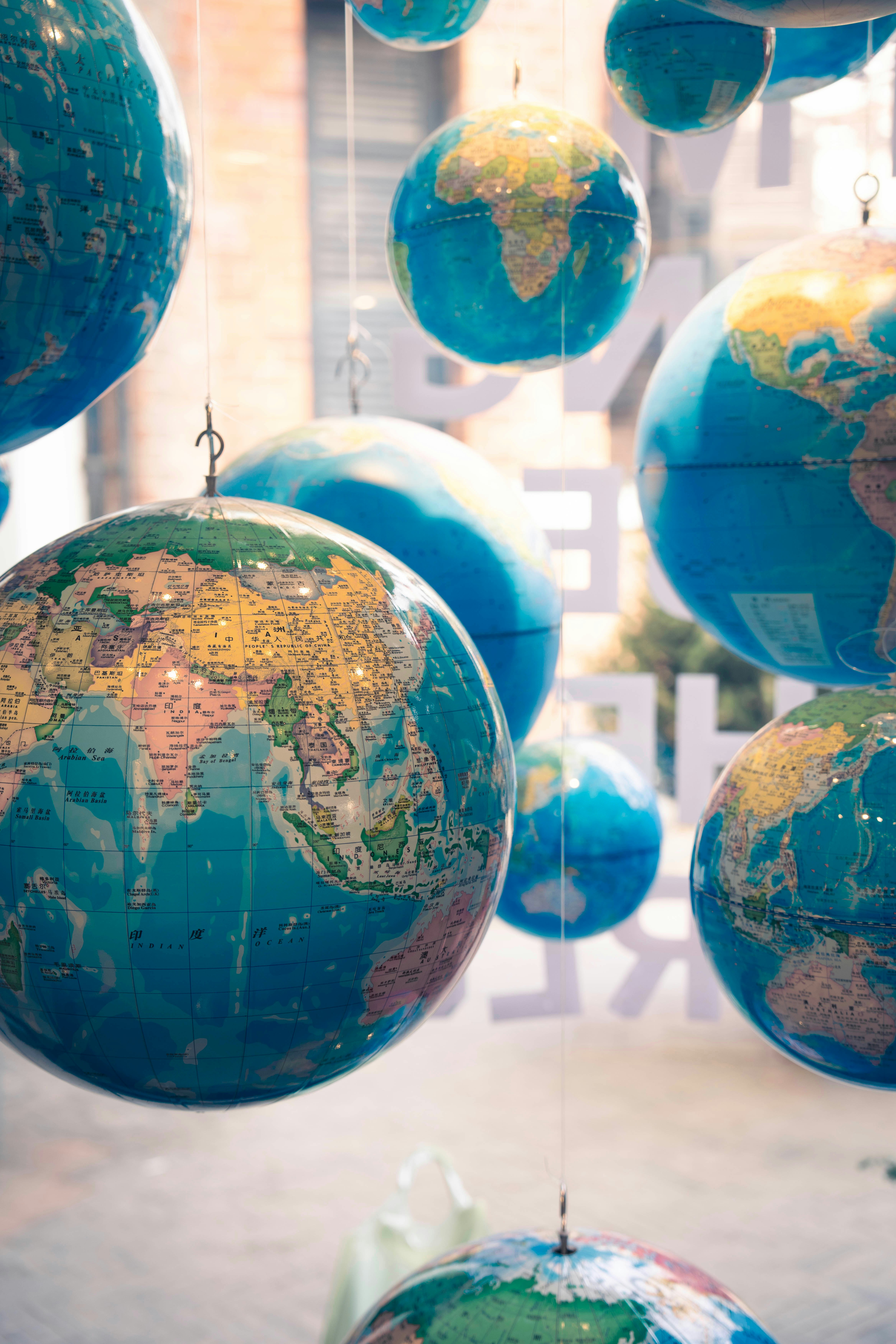 Colorful globes hanging in a display, showcasing various continents and oceans. The arrangement creates a playful and educational atmosphere.