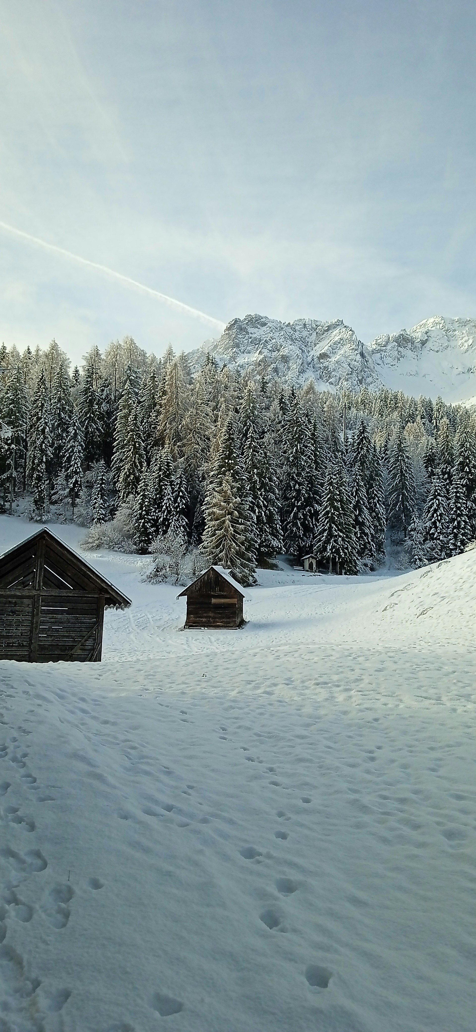 A couple of cabins sitting in the middle of a snow covered field photo ...