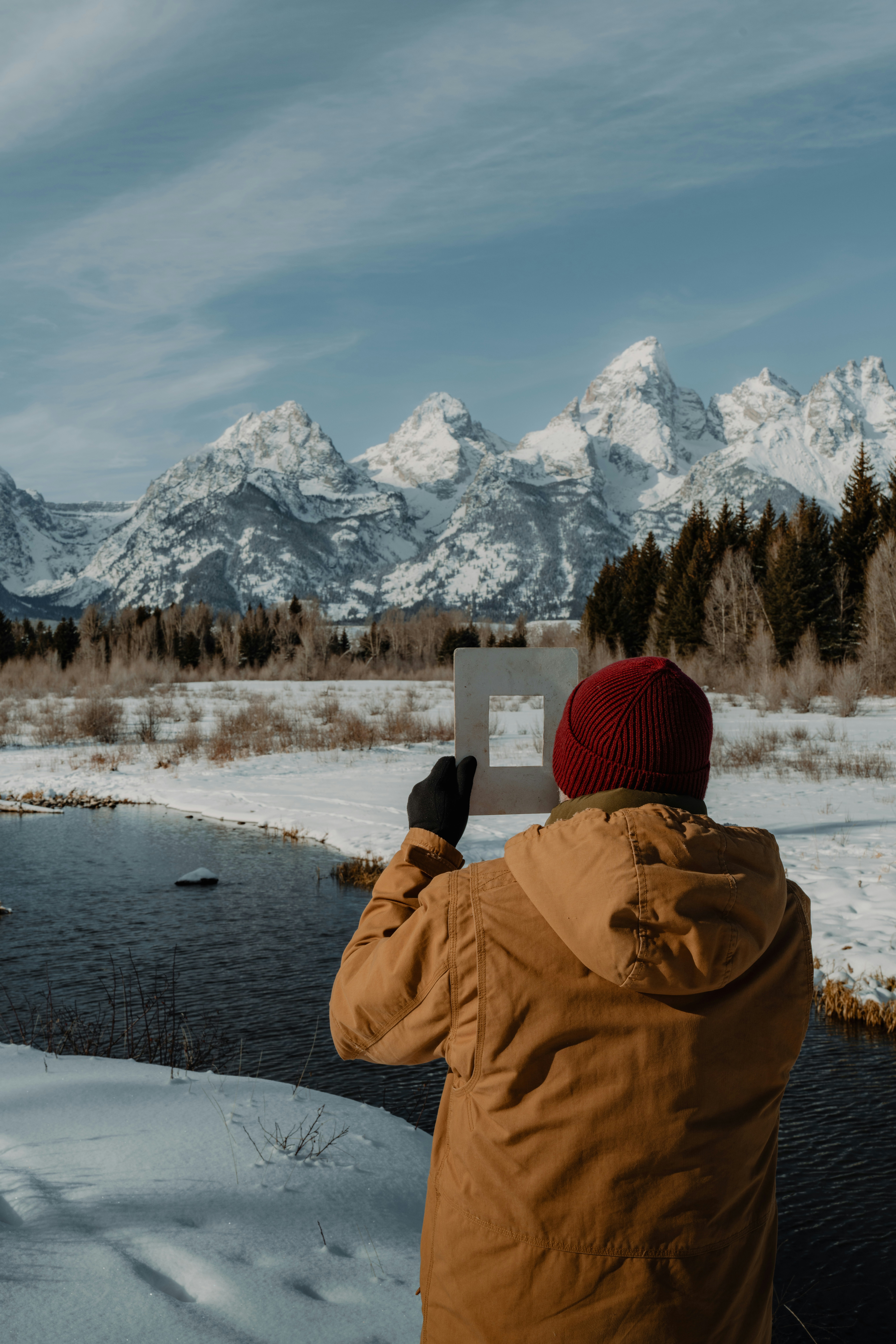 Framed in Snow: A Traveler's View of Snow-Capped Peaks Across a Quiet River