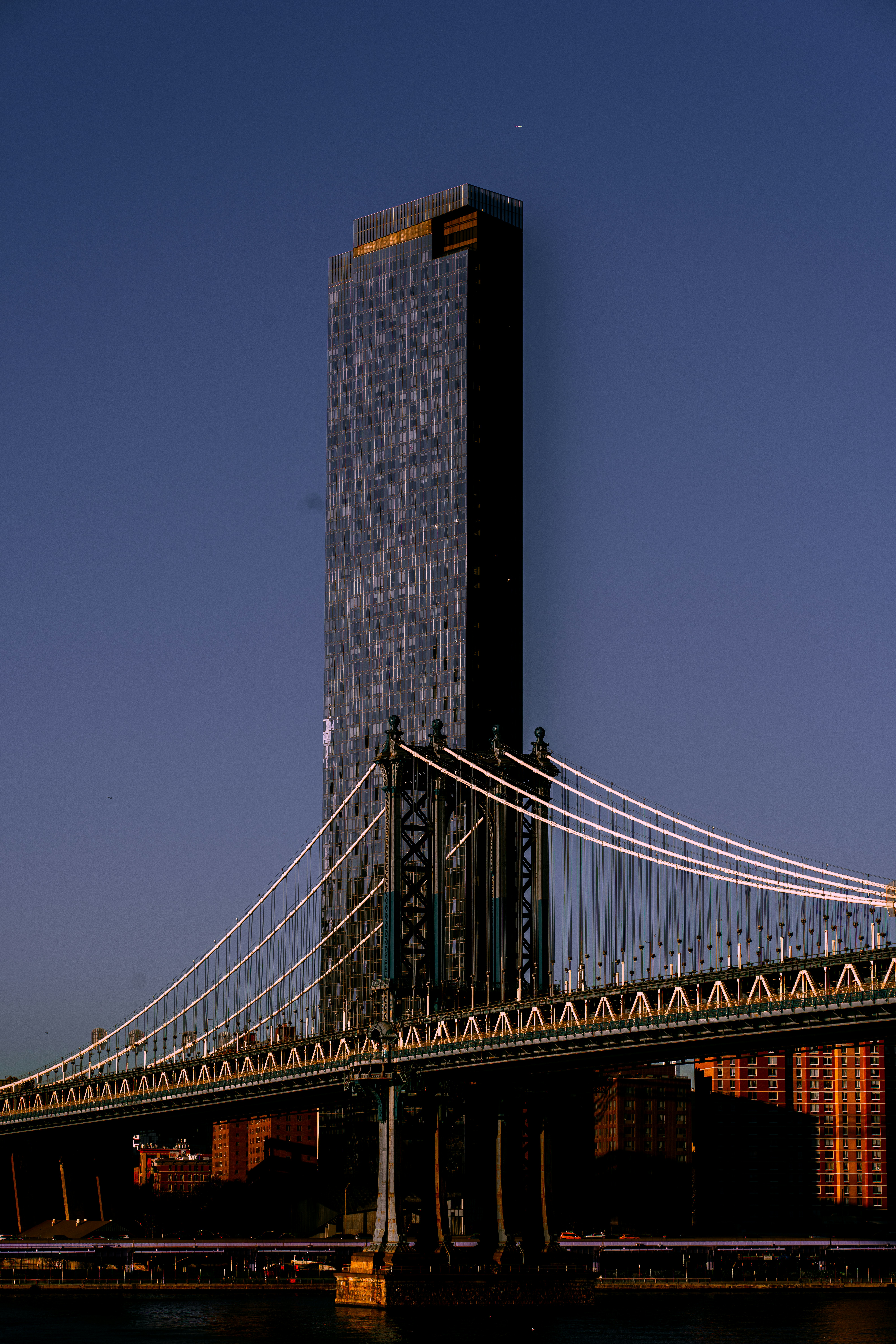 Blue Hour Spire: Glass Tower Rising Above a Cable-Stayed Bridge