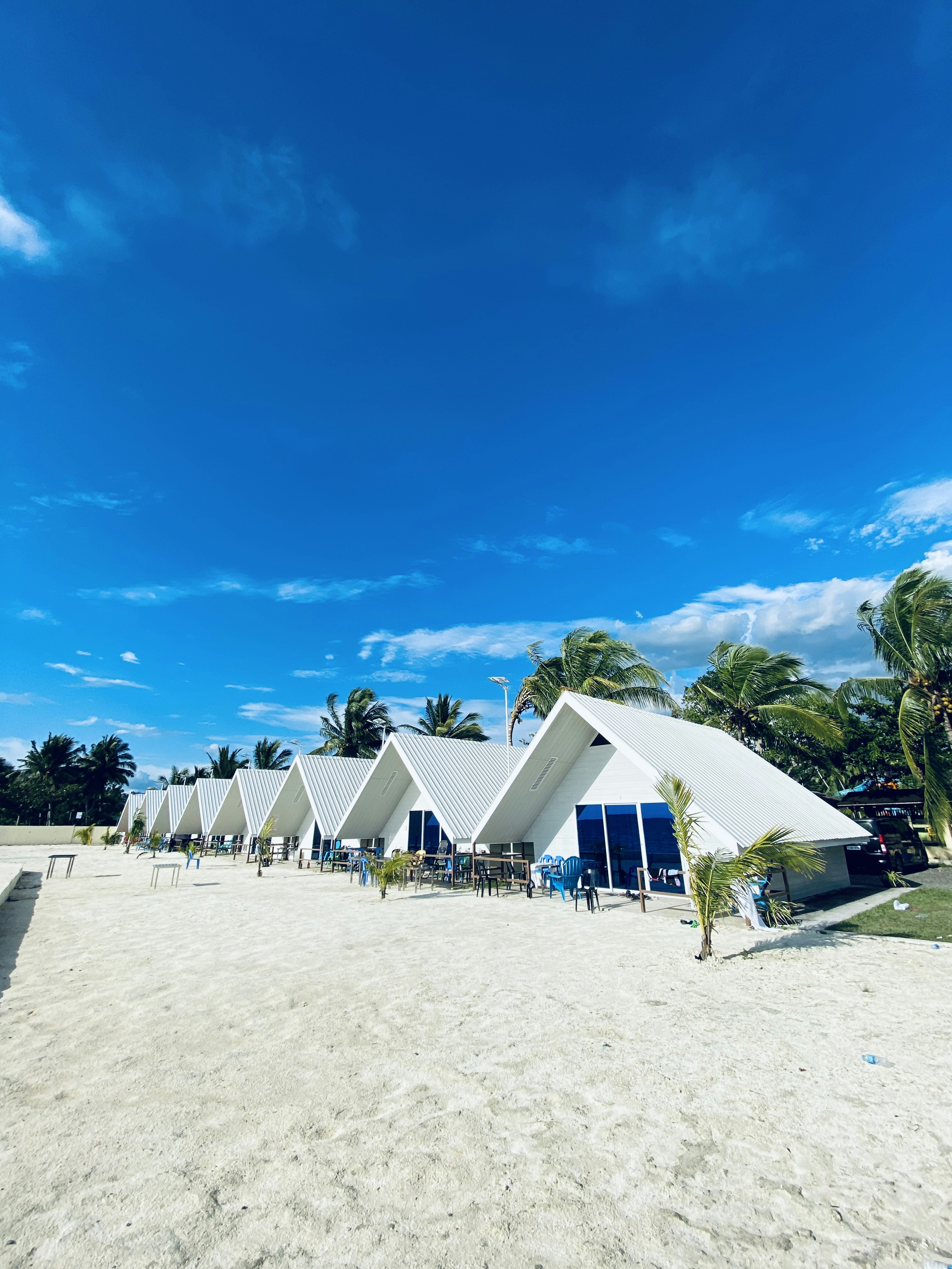 Geometric A-Frame Cabins Parade Along a Sunlit Beach