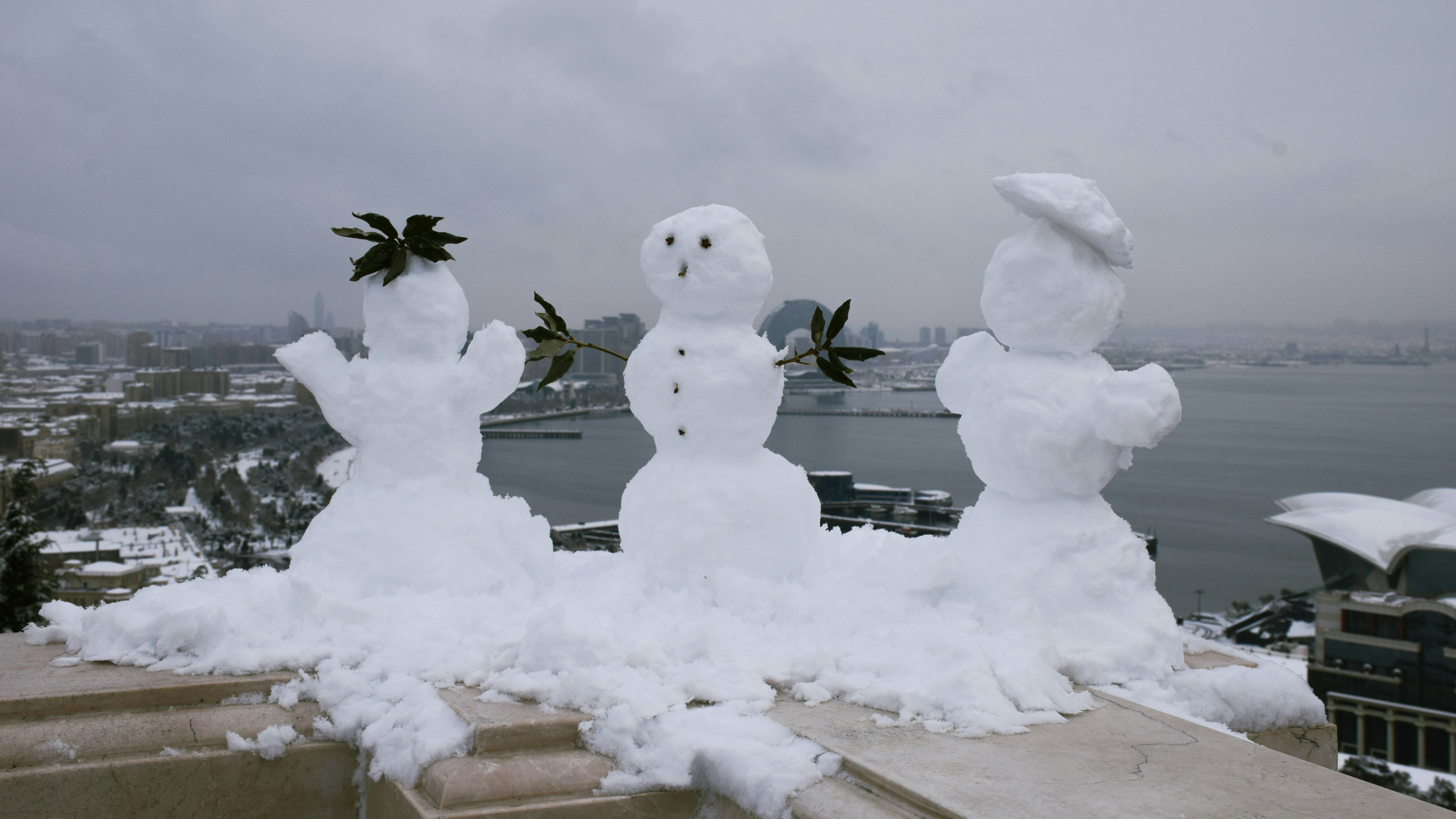 A group of snowmen sitting on top of a roof photo – Free Baku Image on ...
