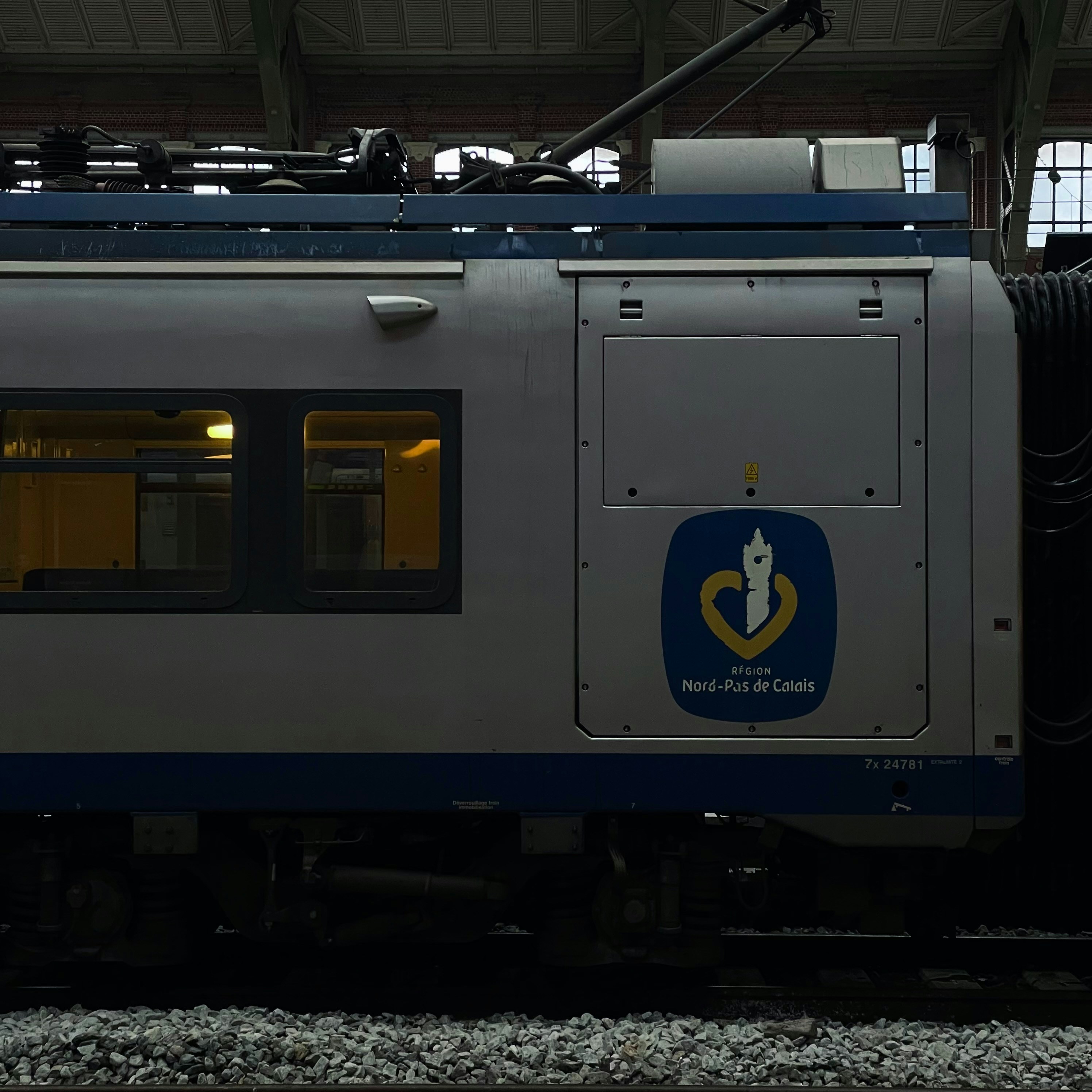 Blue Crest at Rest: A Silent Train Car in a Dim Station