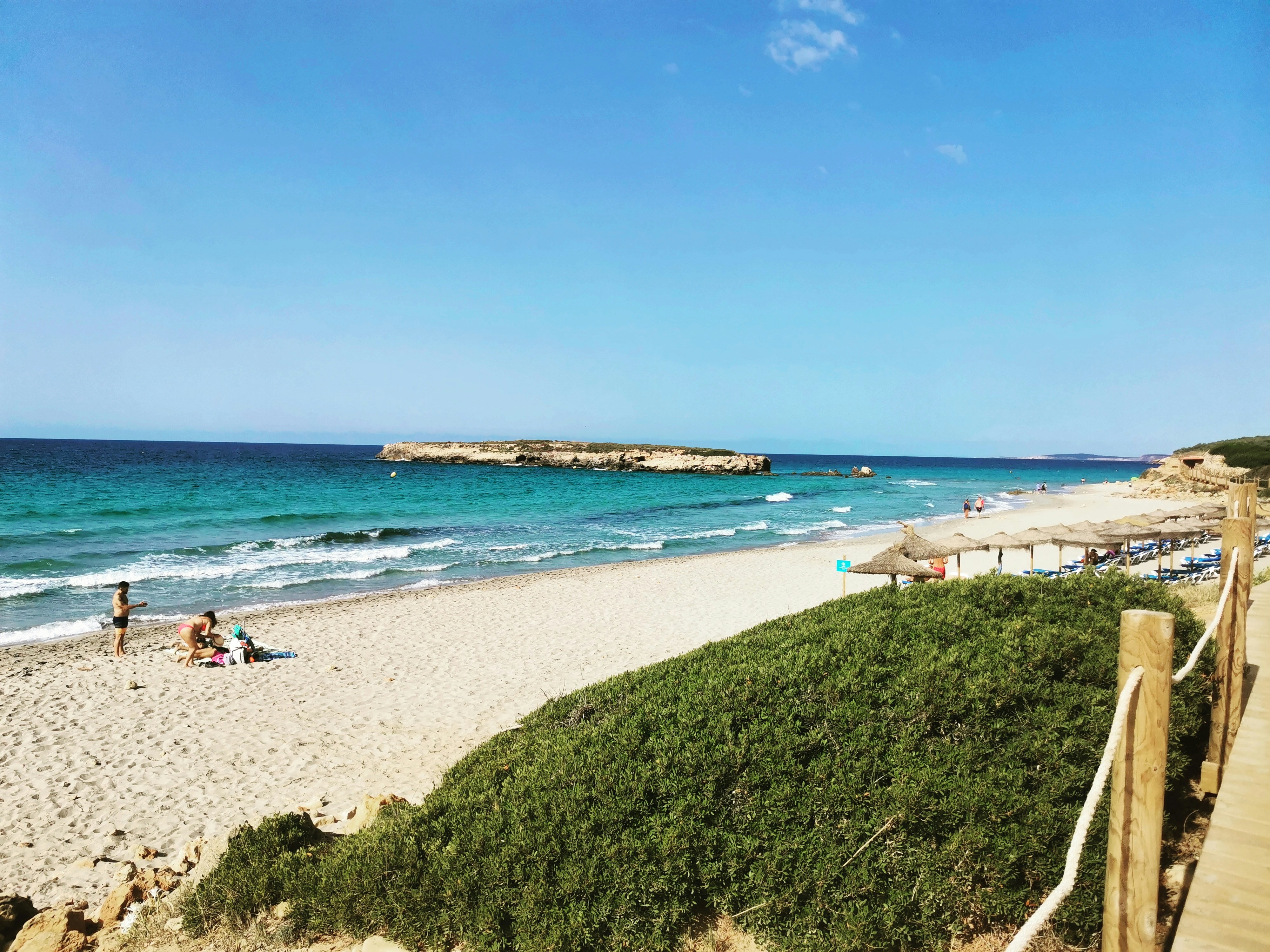 A sandy beach with a few people on it photo – Free Minorca island Image ...