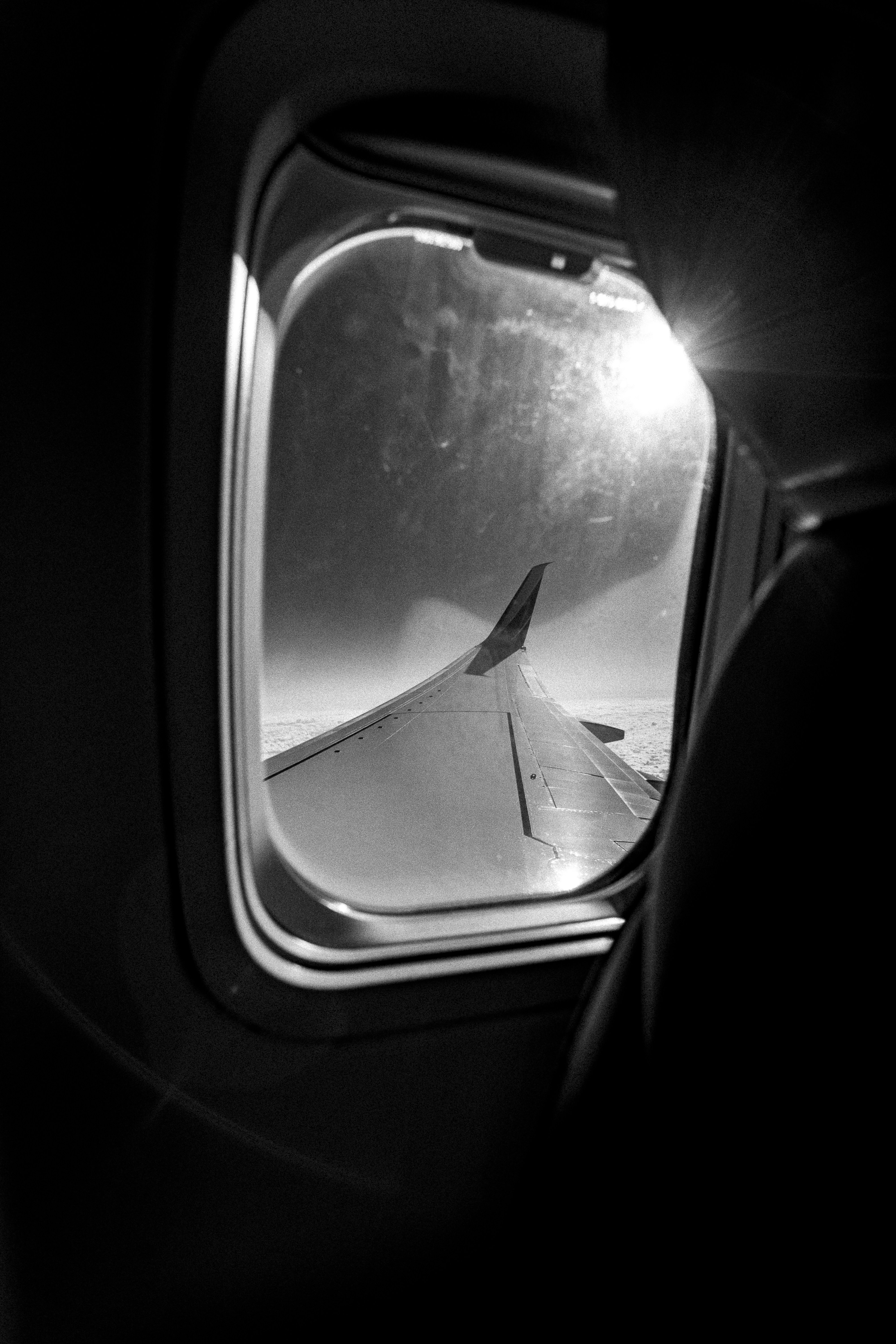 Wing in Black and White: A Window-Seat Moment Above the Clouds
