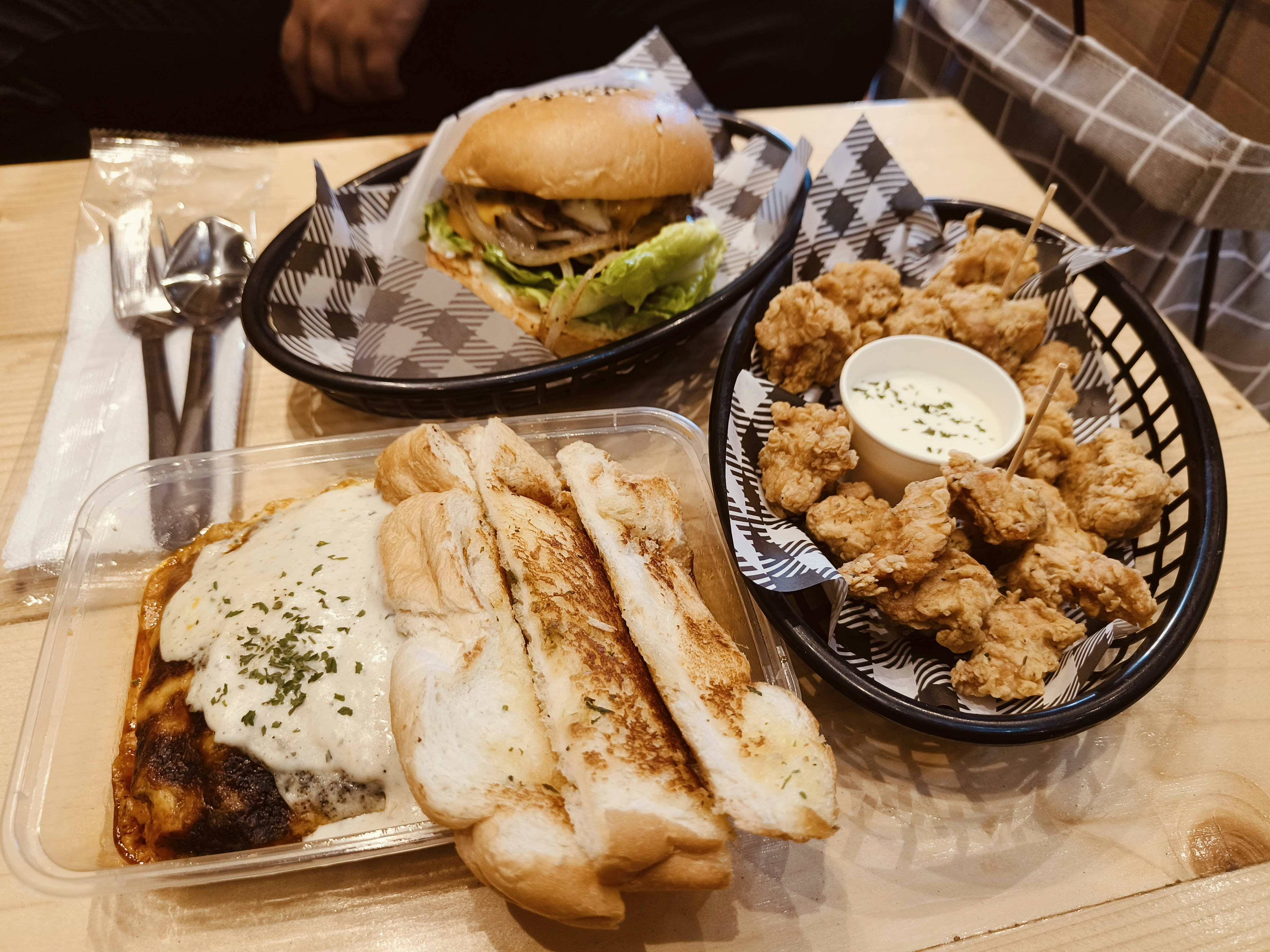 Club House Burger, Lasagna, & chicken shots | a couple of plates of food on a table