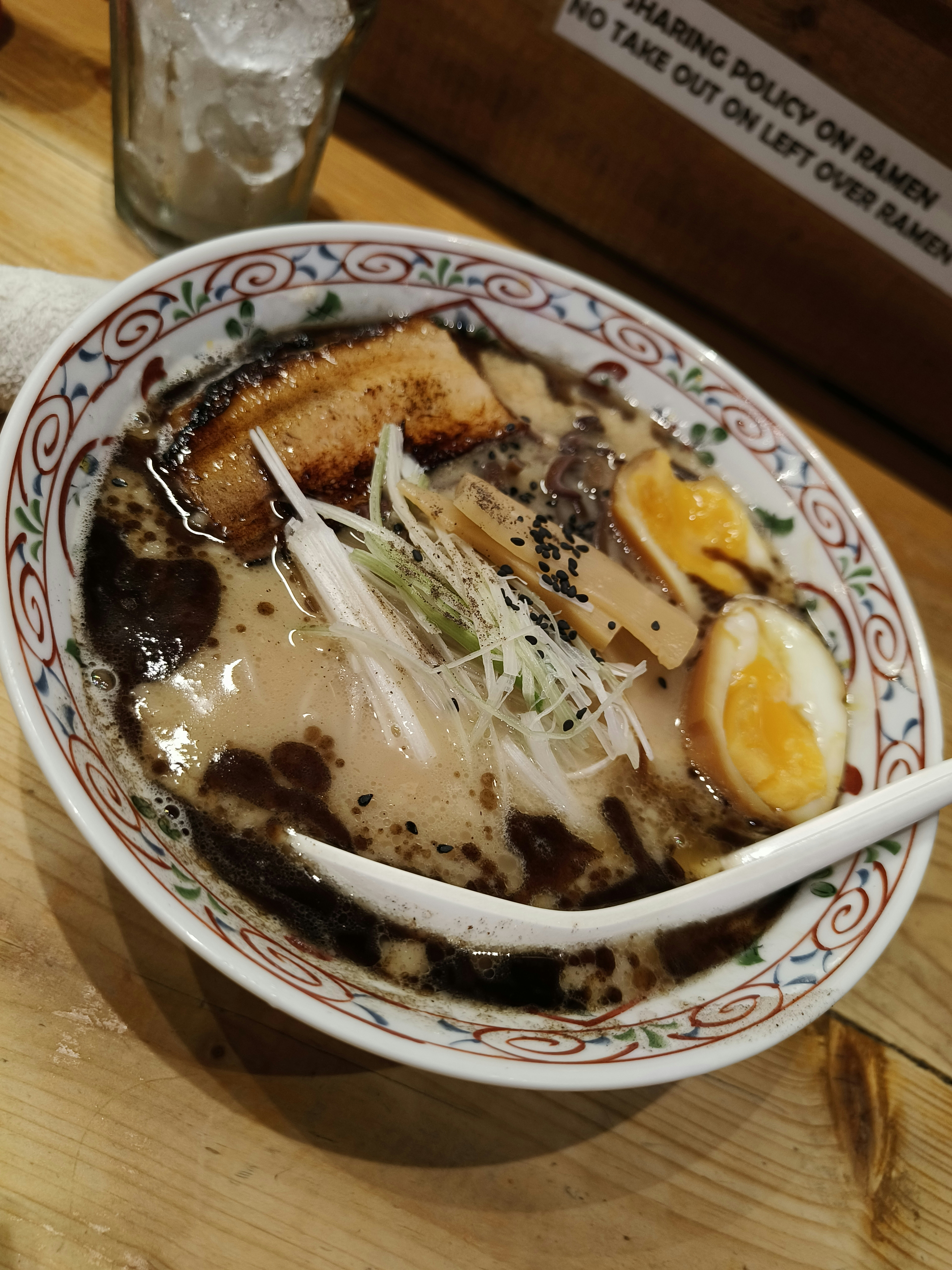 A beautifully crafted bowl of ramen featuring rich broth, tender pork belly, marinated eggs, and fresh scallions.