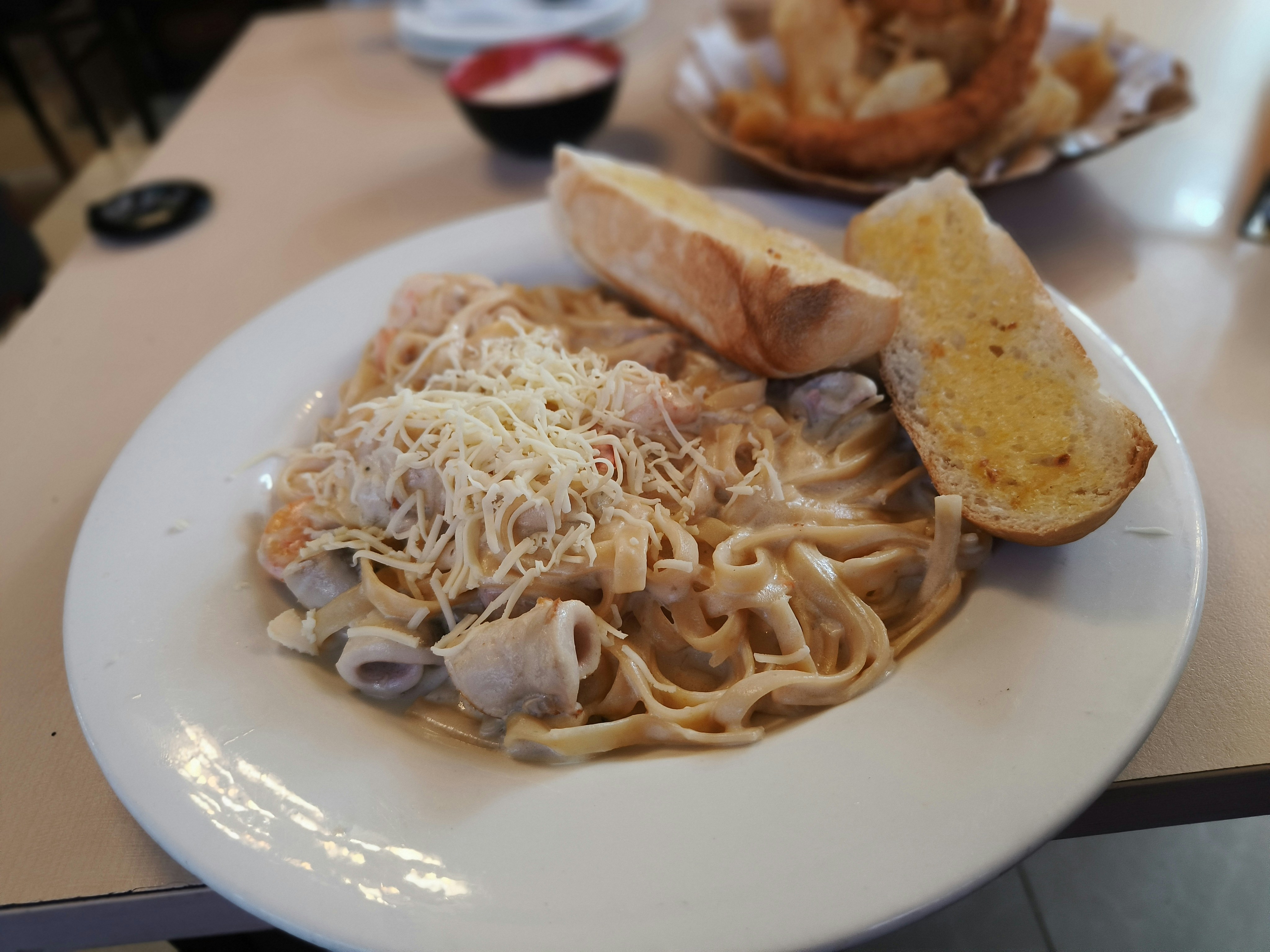 Seafood Carbonara | a white plate topped with pasta and meat