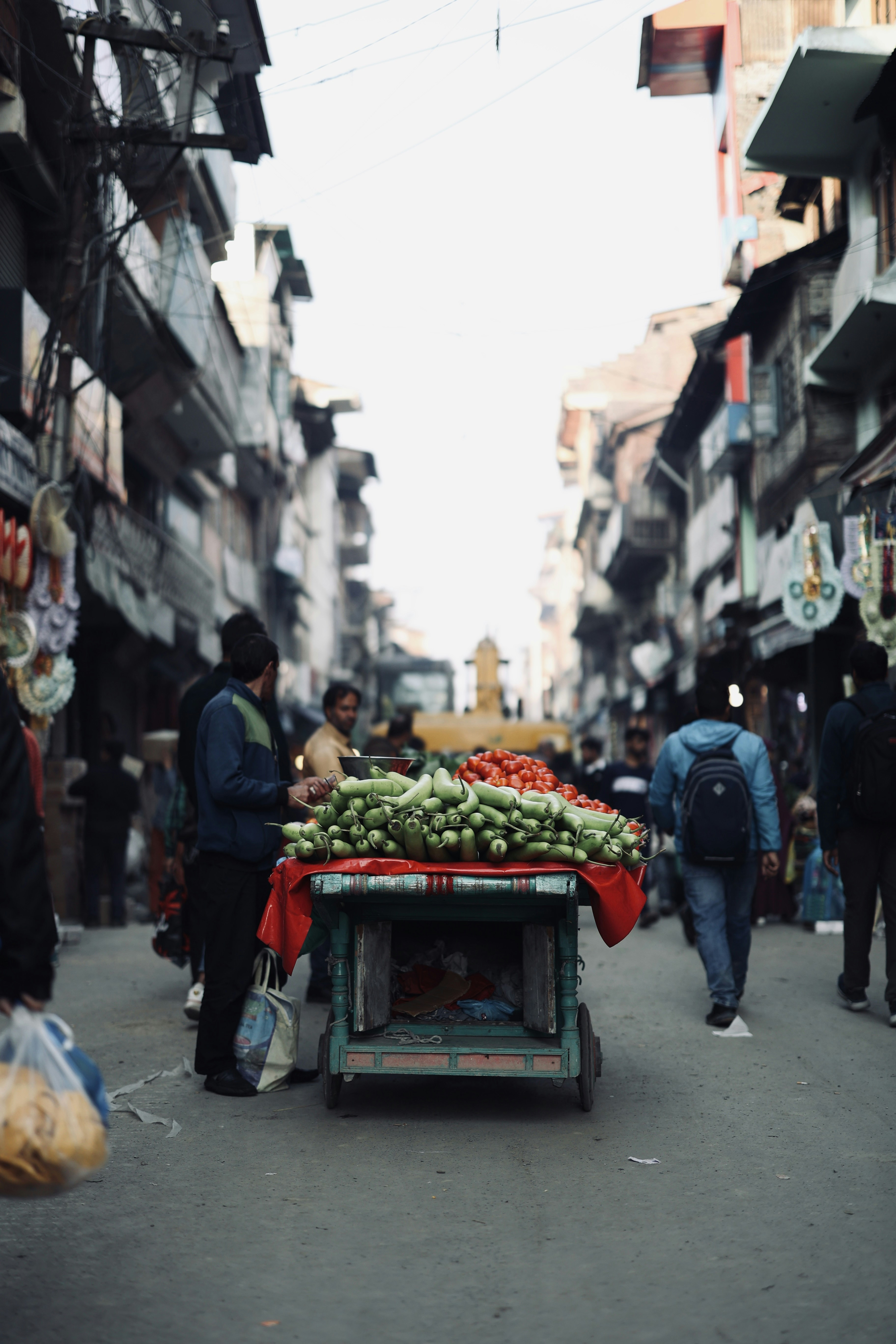 a man is pushing a cart full of produce down the street