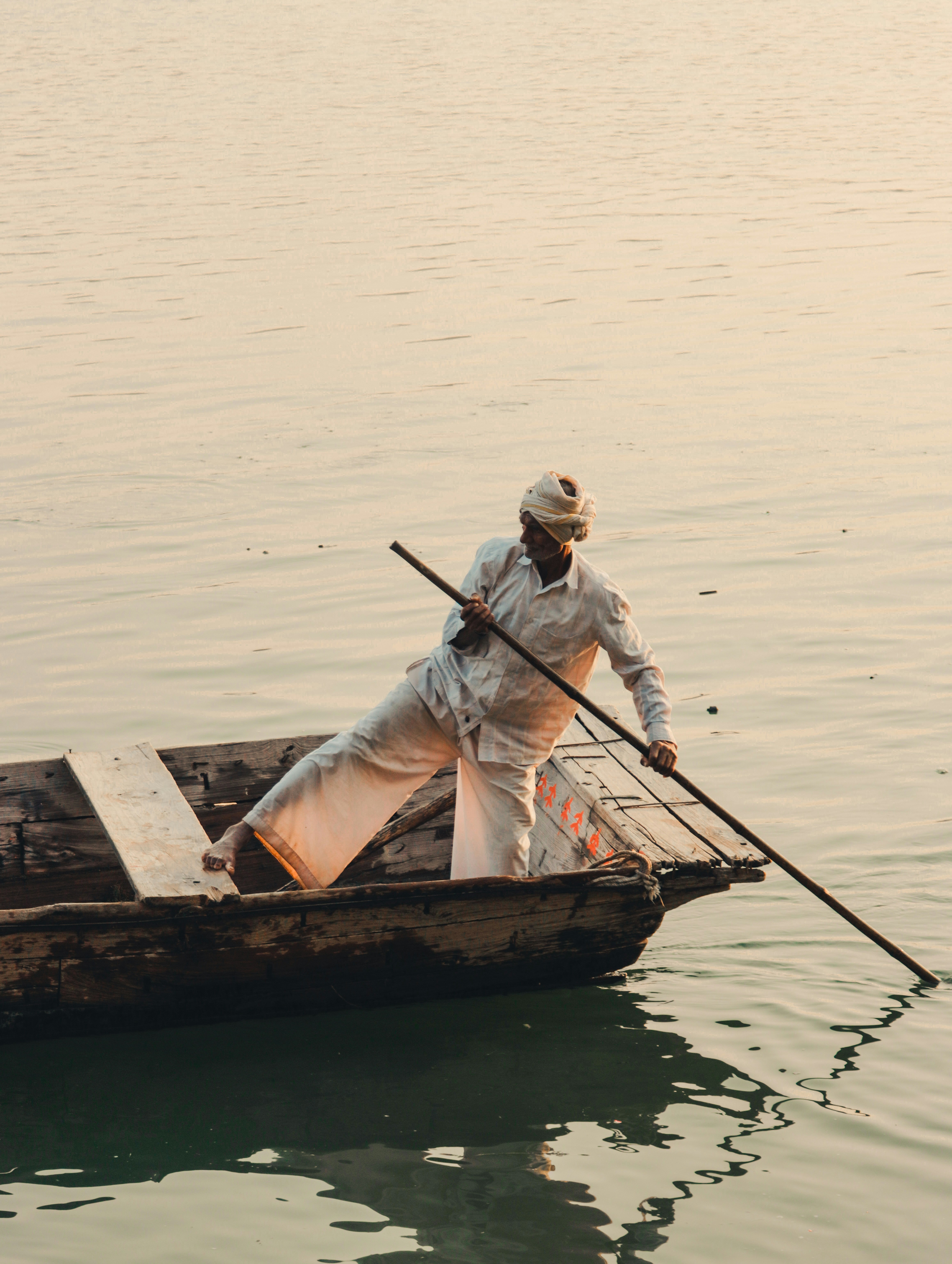 A man rowing a boat on the water photo – Free Street photography Image ...