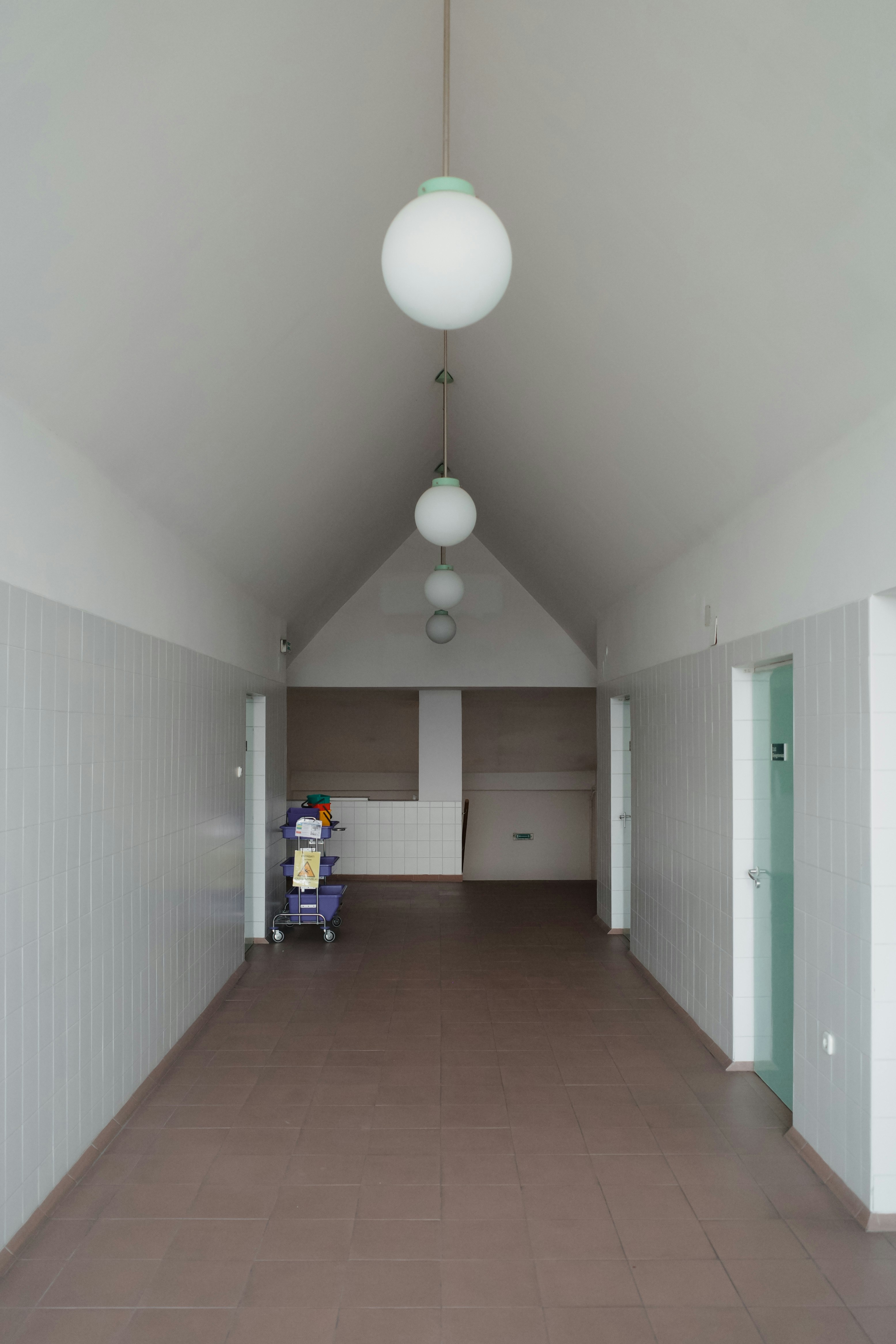 Vanishing Hall: Spherical Lights Line a Quiet Corridor toward a Back Room