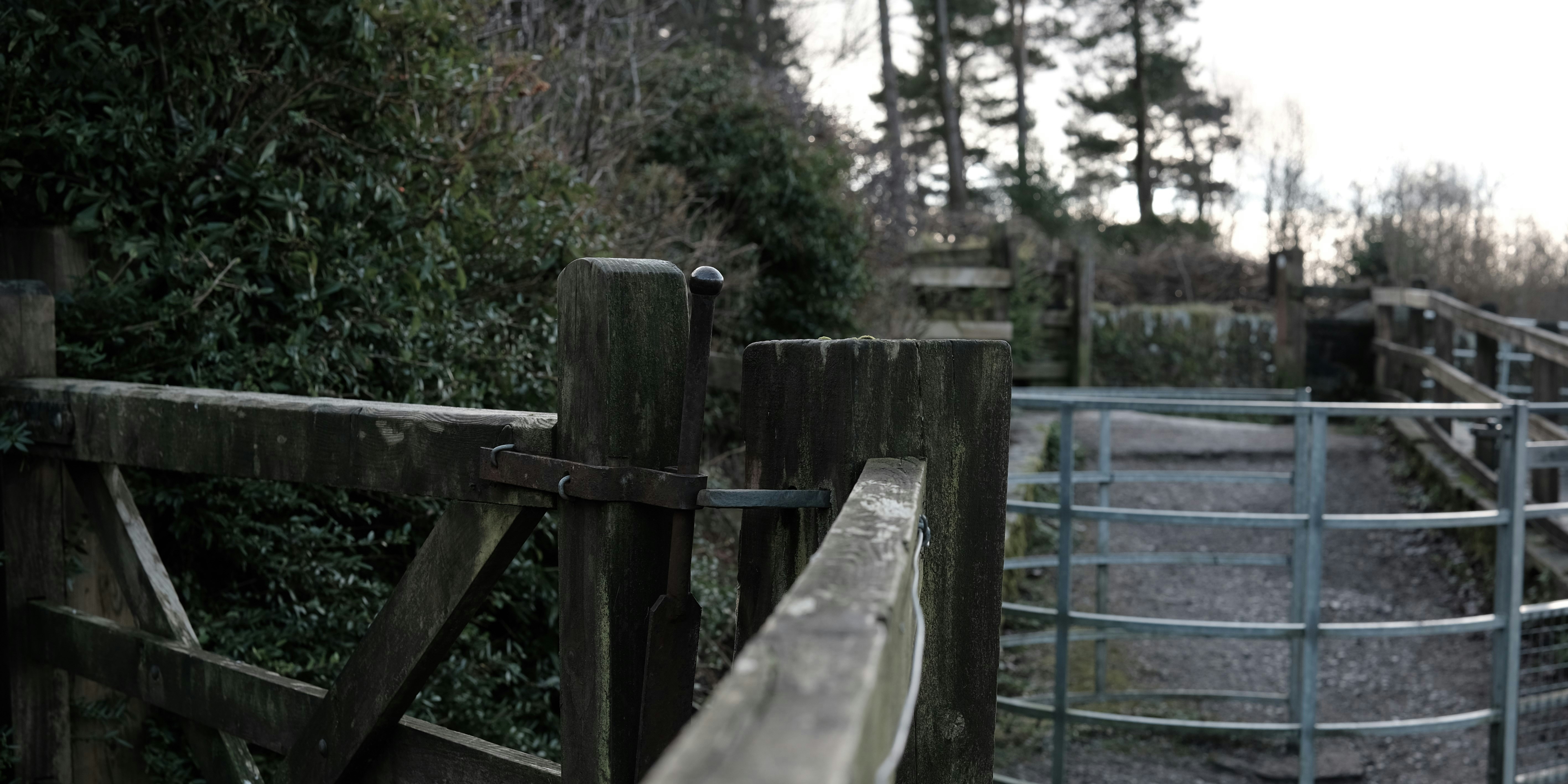 Weathered Gate Framing a Quiet Gravel Path at Dusk