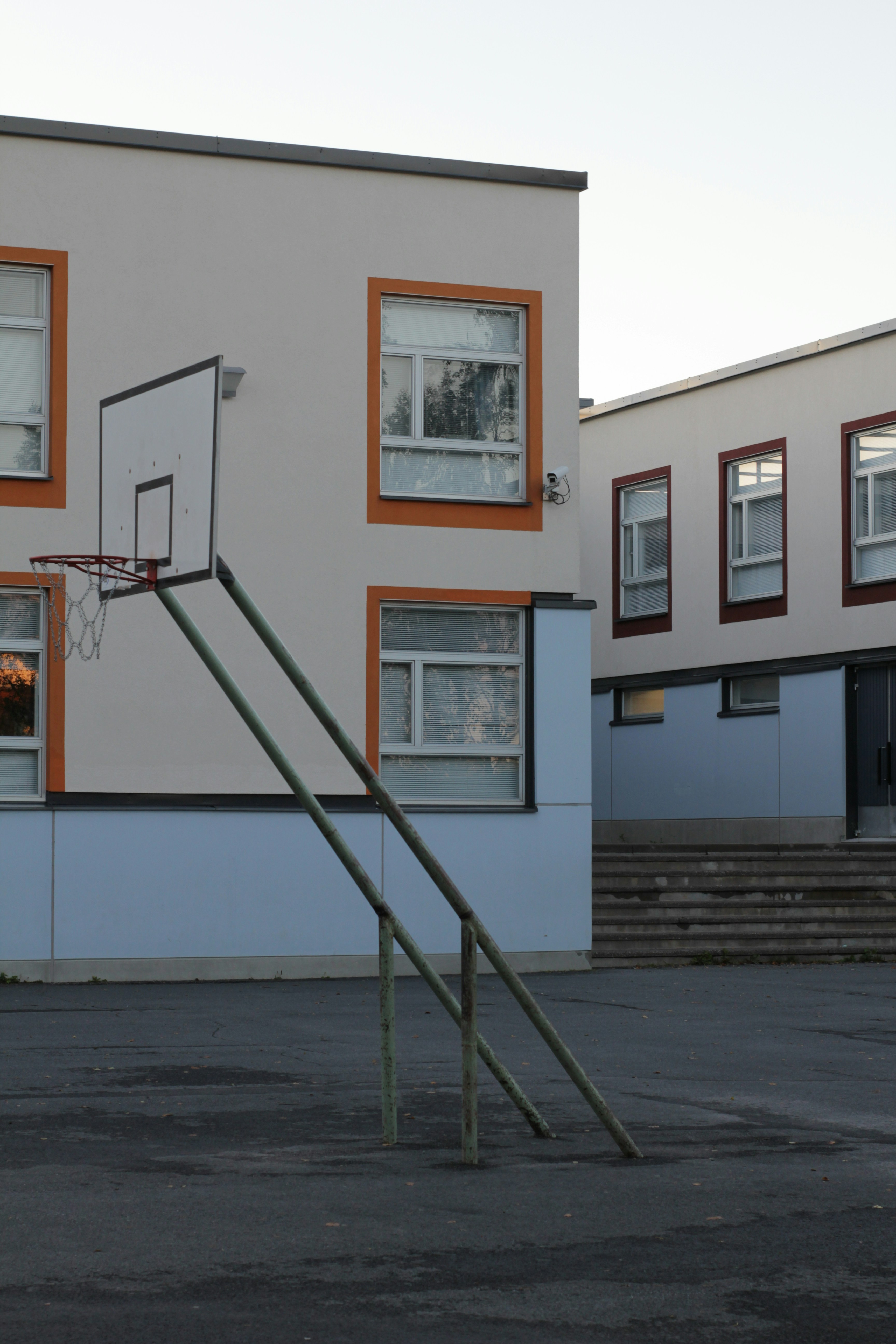 A basketball hoop in front of a building photo – Free School exterior ...