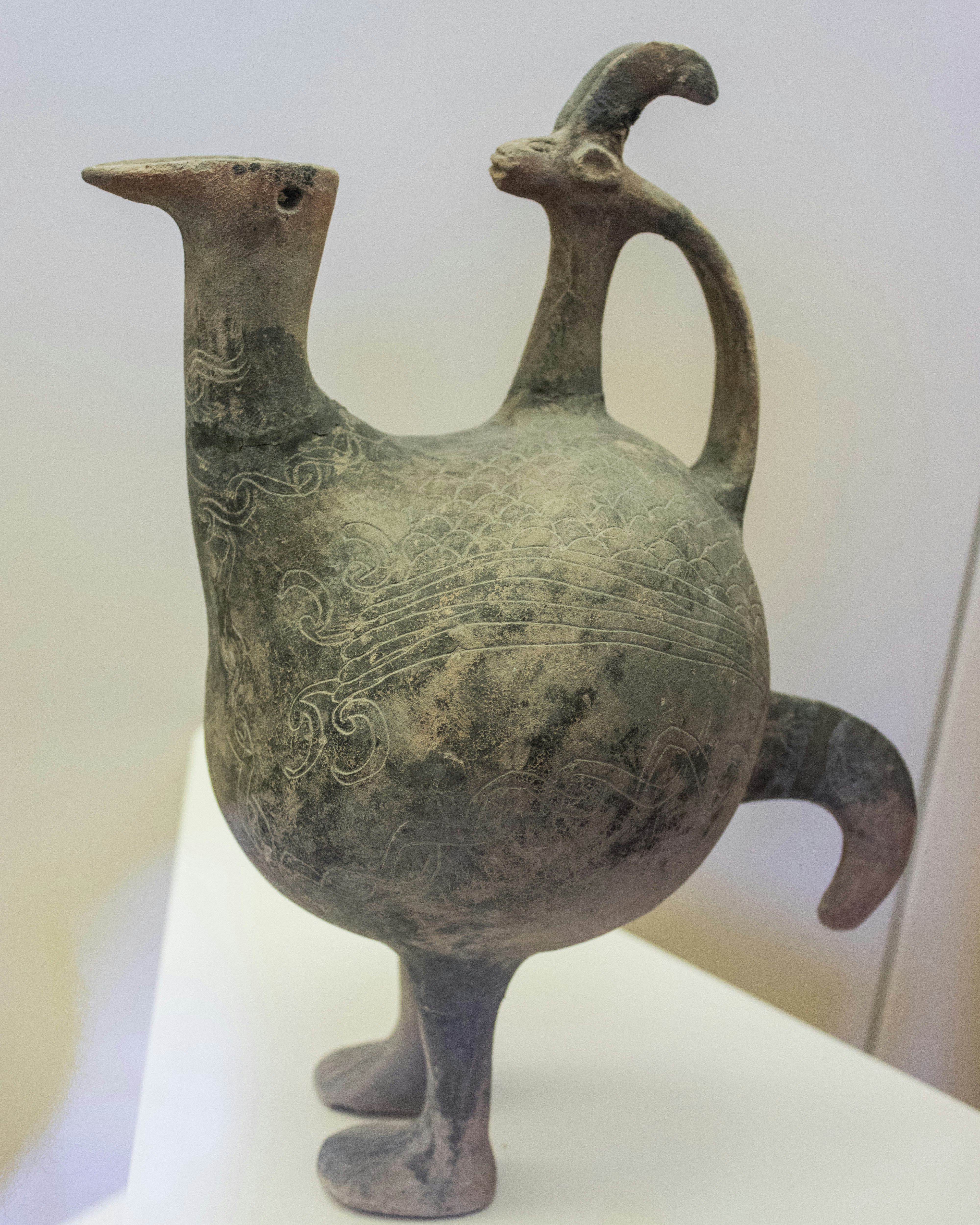 The Four-Legged Teapot: A Weathered Ceramic Vessel with Ocean-Wave Engravings
