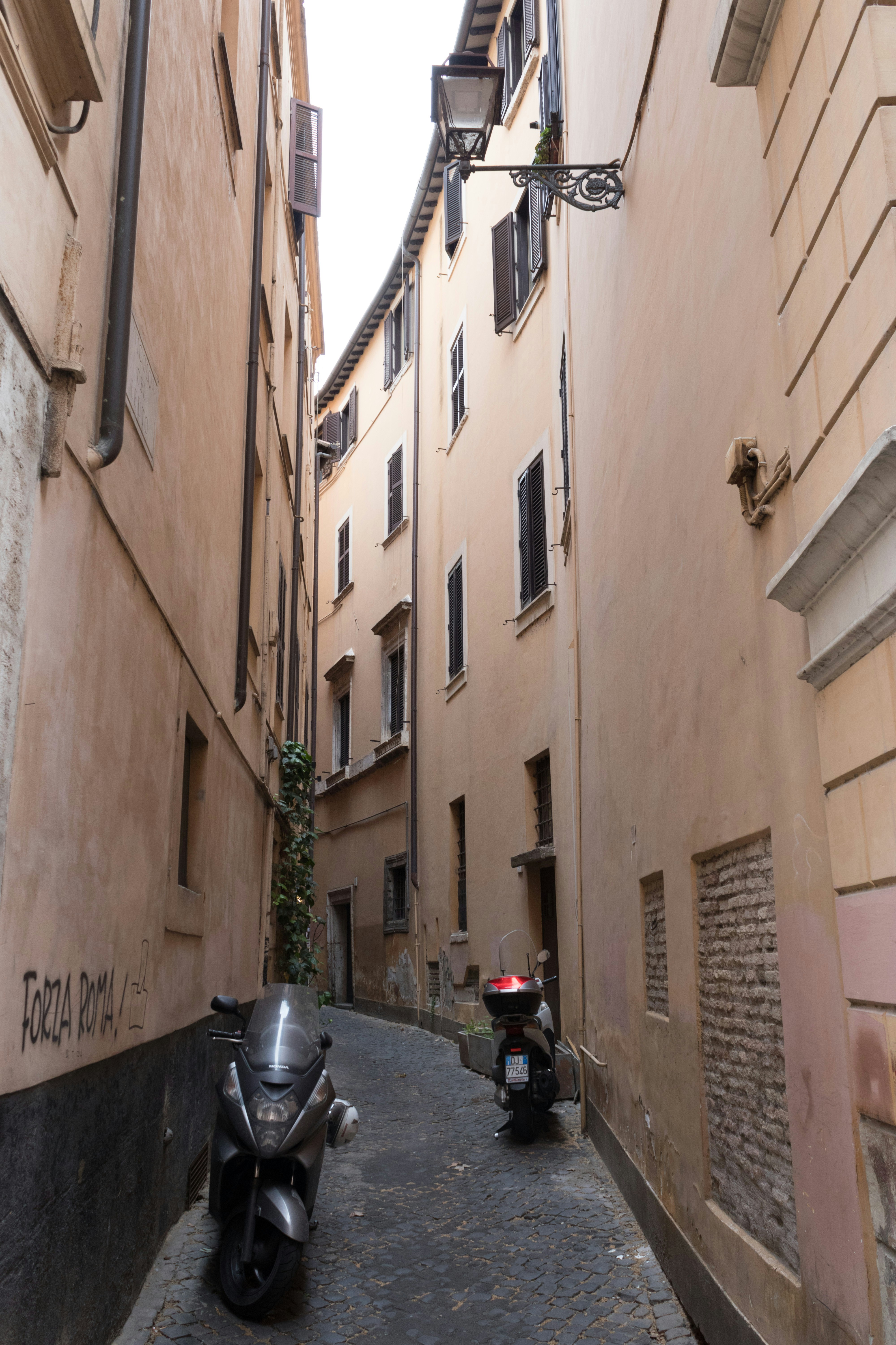 Roman Alleyway: Scooters Framed by Sun-Warmed Beige Walls