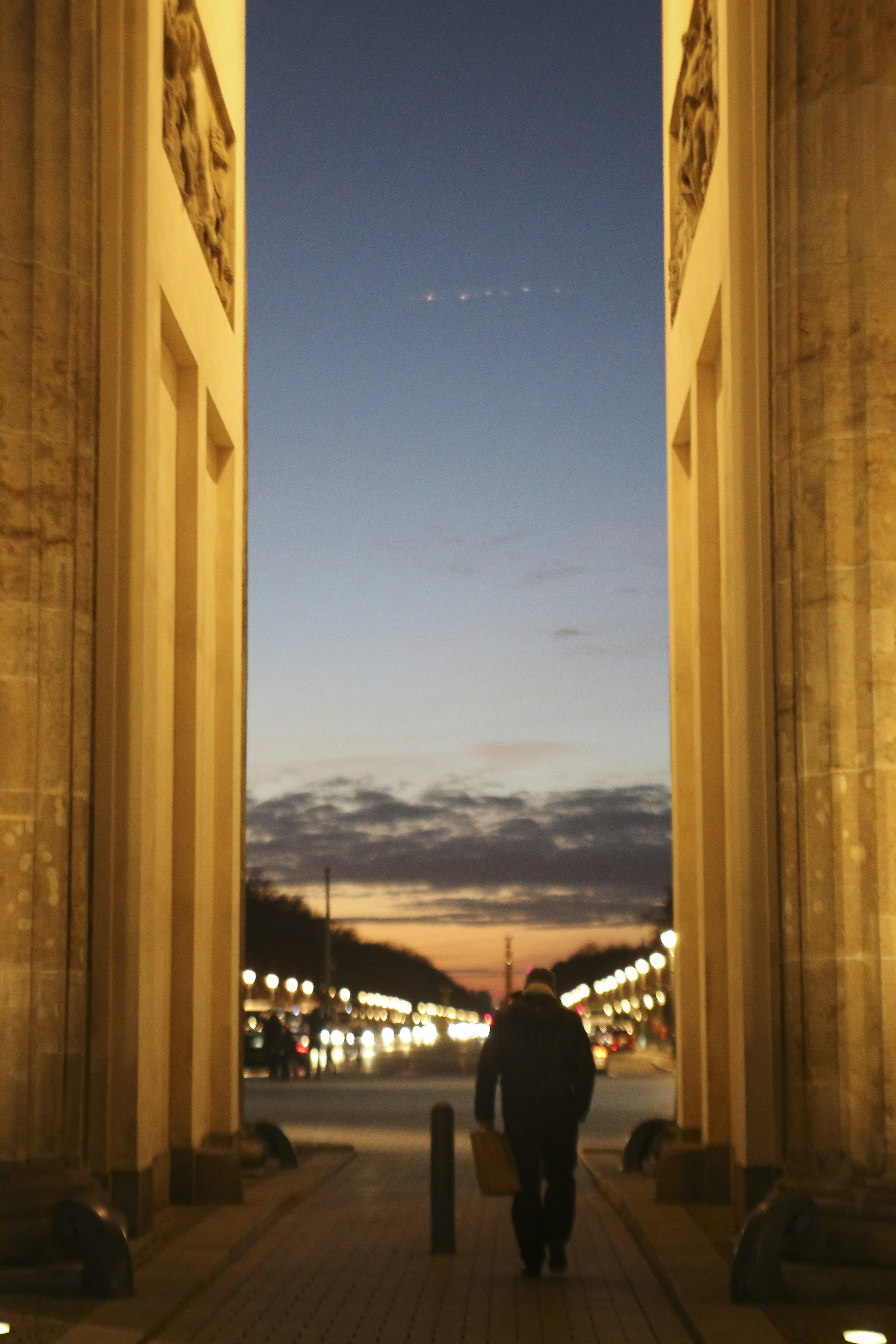 Through the Arc: Evening Stroll Beneath Lantern-lit Columns