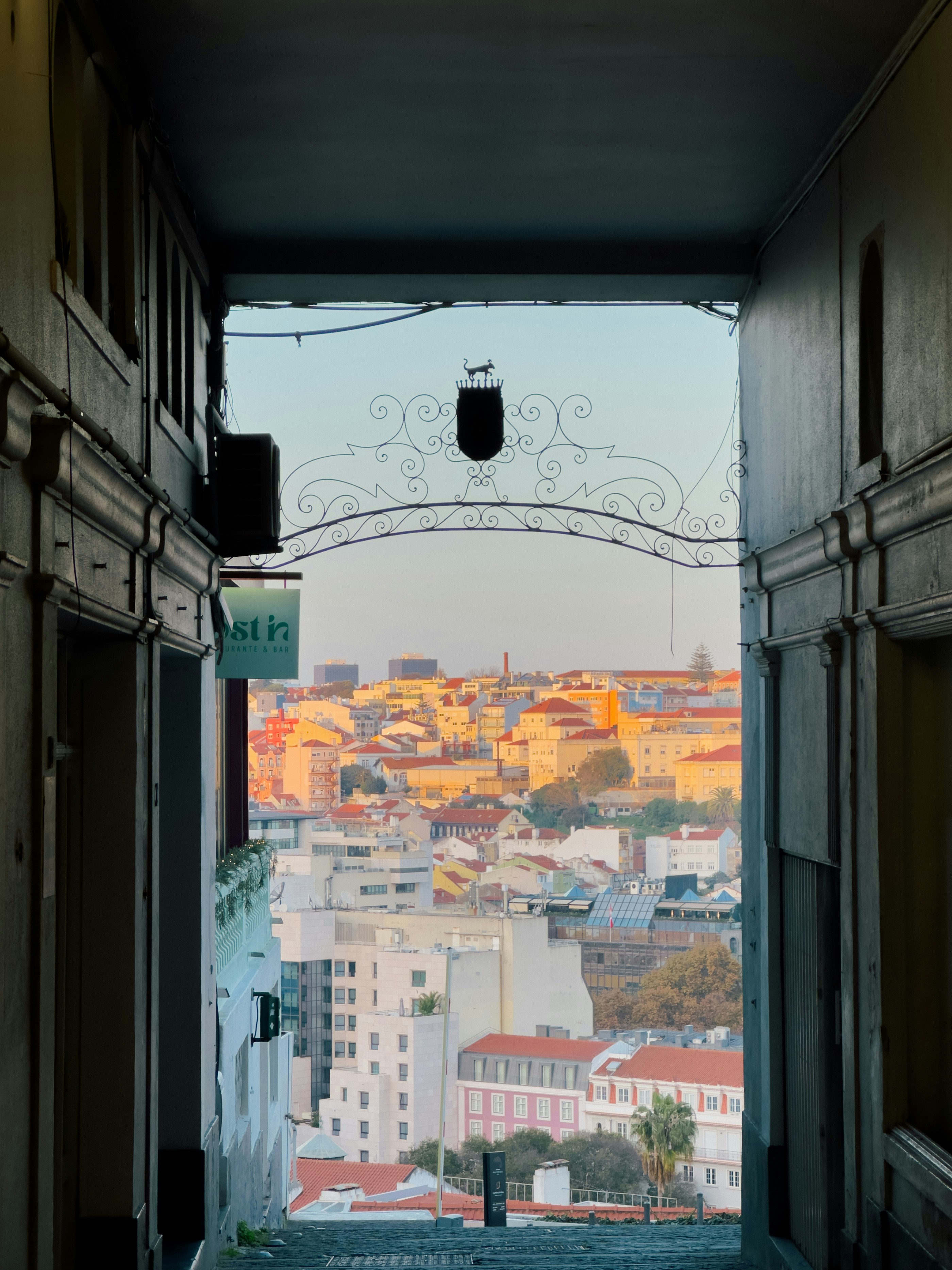 Gatehouse Vista: An Ornate Arch Framing a Sunlit City Horizon
